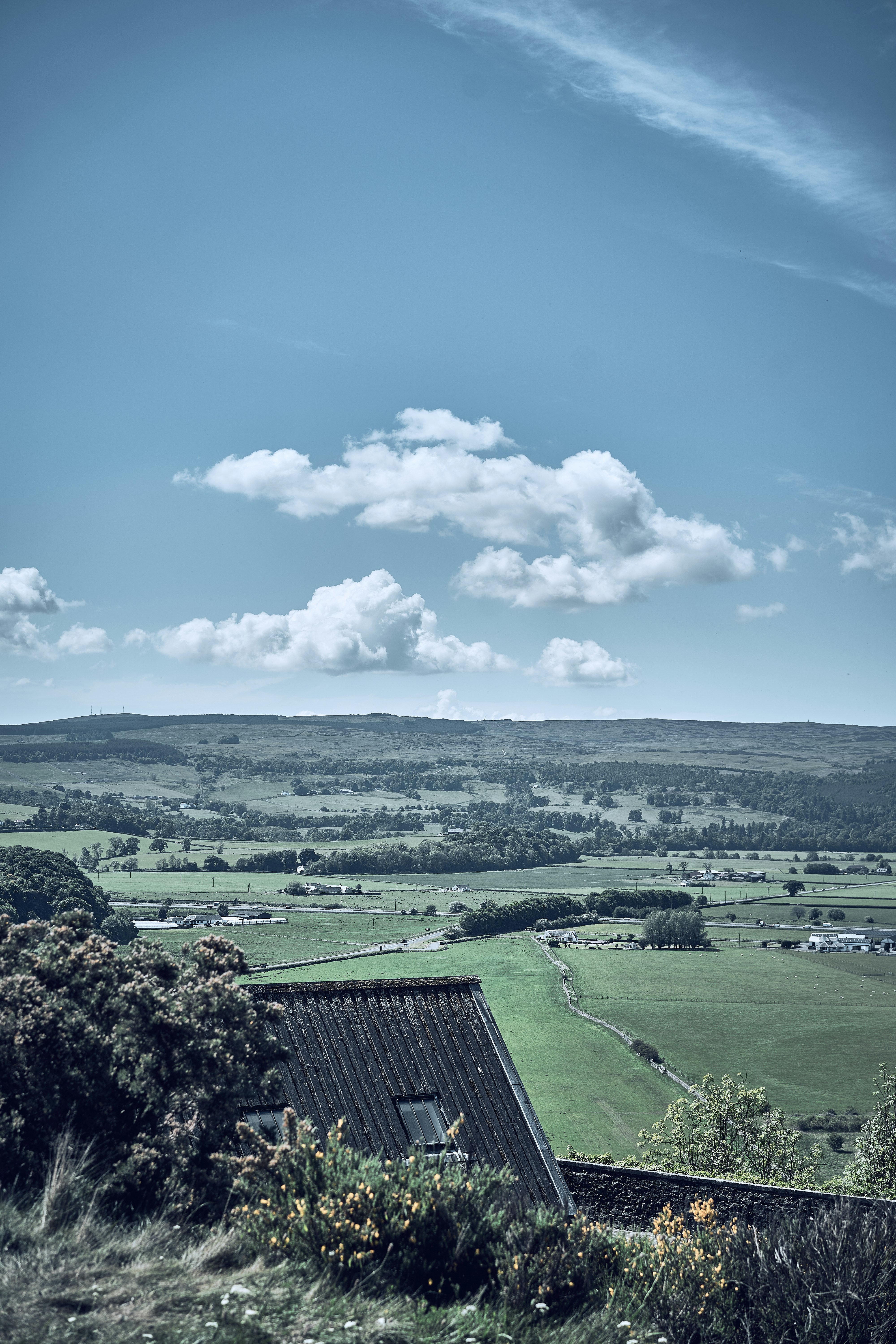 Horizon of Rolling Fields from a Hillside Farm with Rooftop in the Foreground
