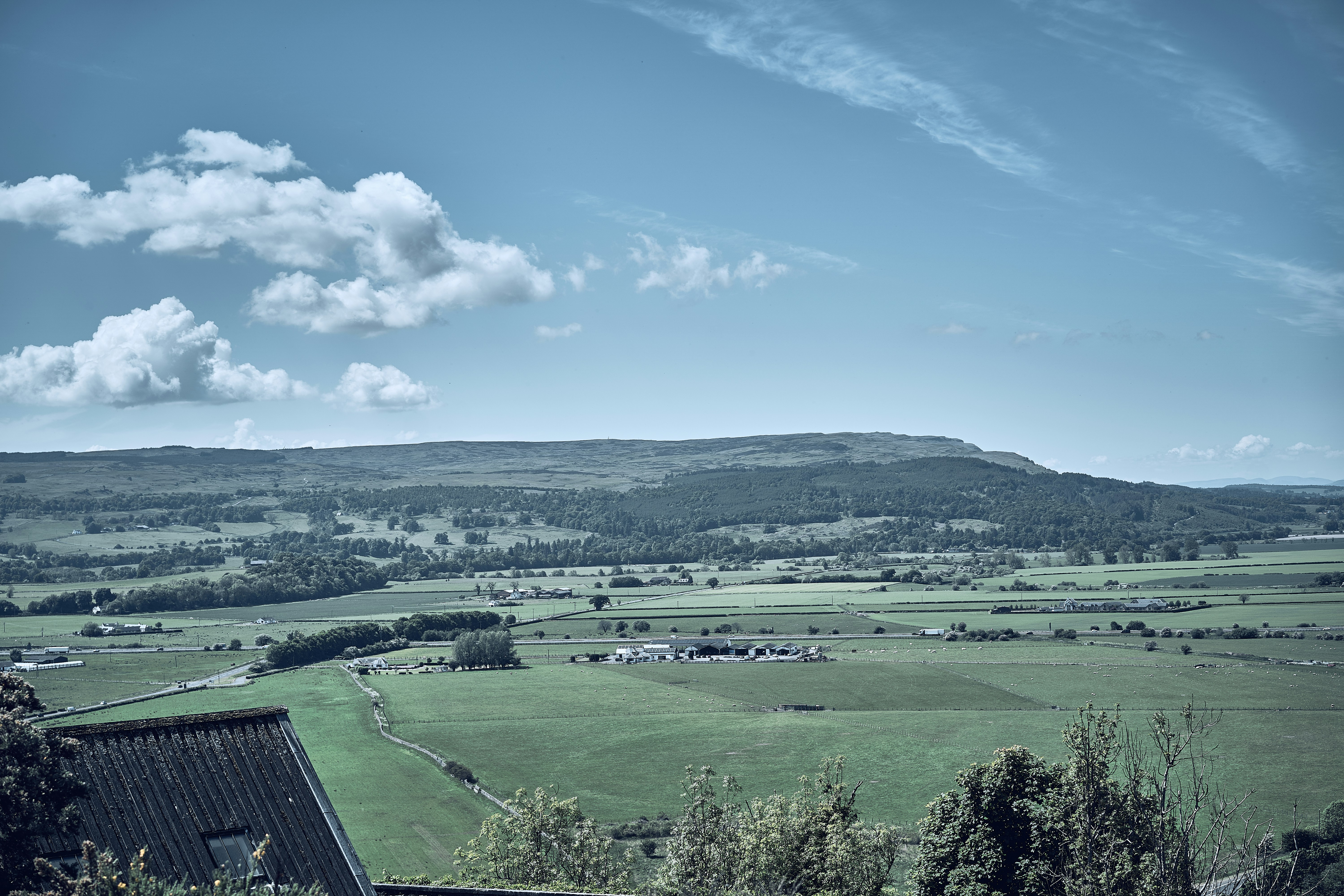 Rolling Green Valleys Beneath a Bright Sky