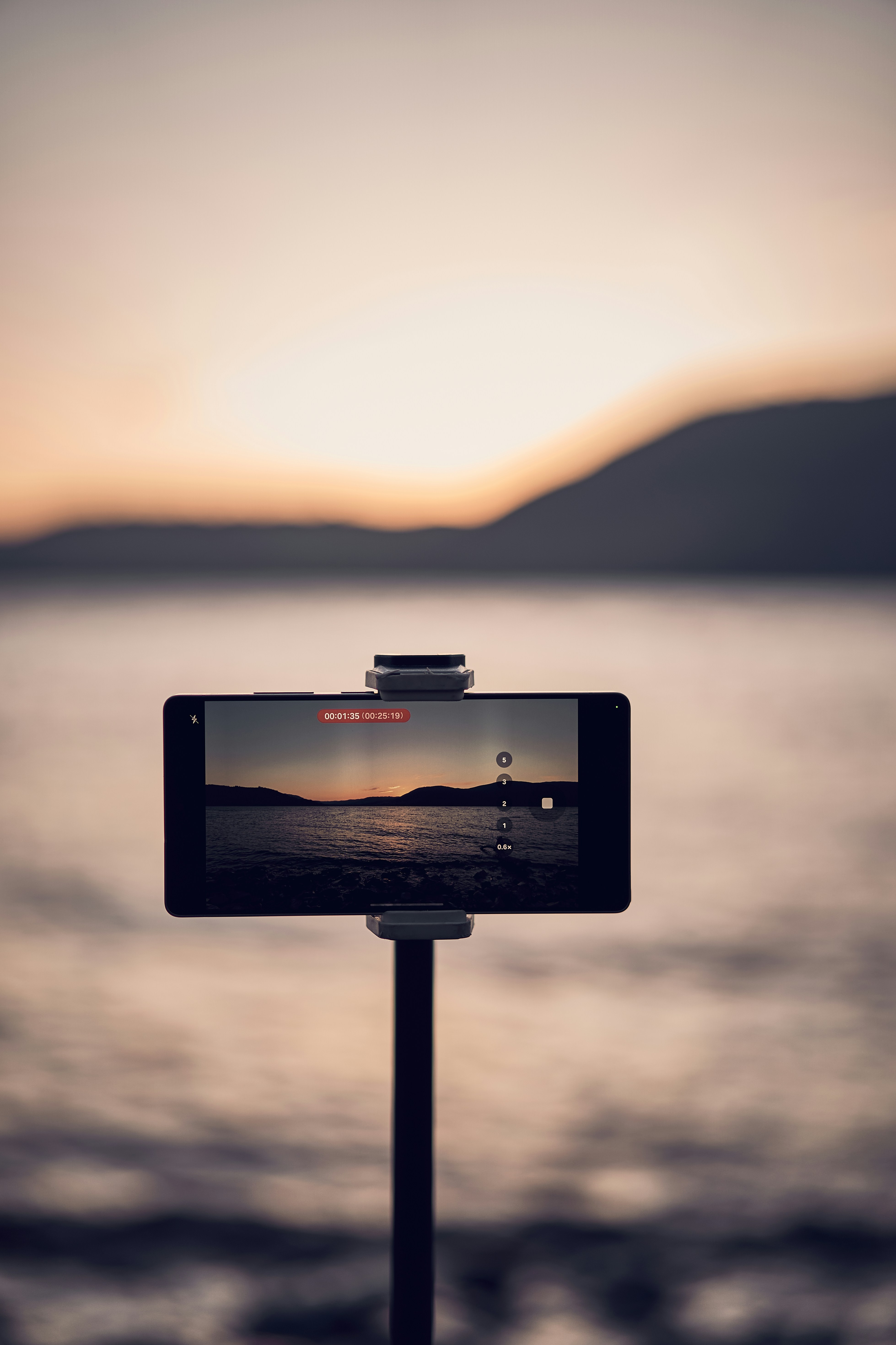 Sunset Horizon Refracted: A Phone on a Podium Captures the Quiet Moment