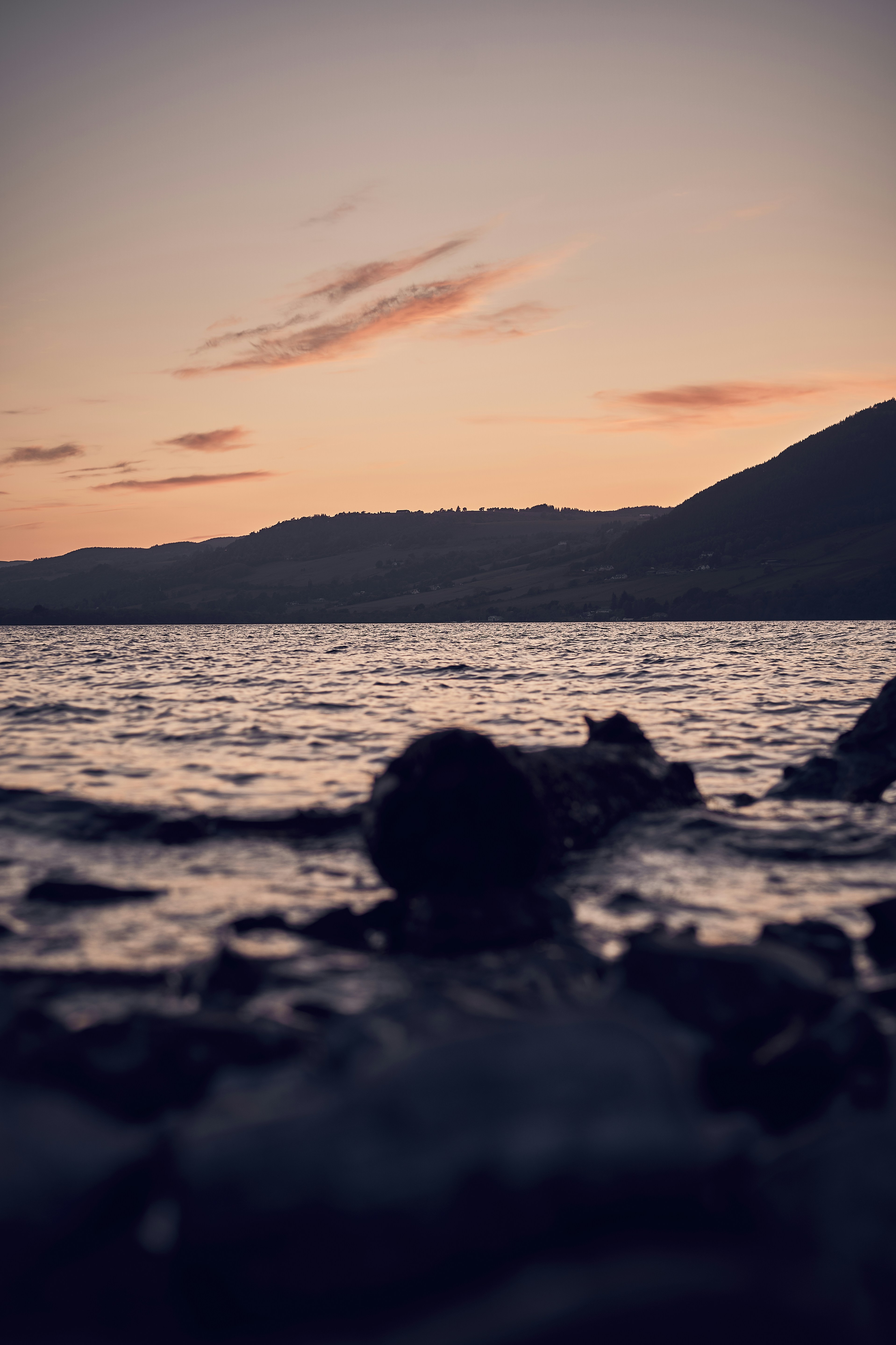 Dusk on the Quiet Fjord: Silhouetted Rocks Meet the Distant Hills