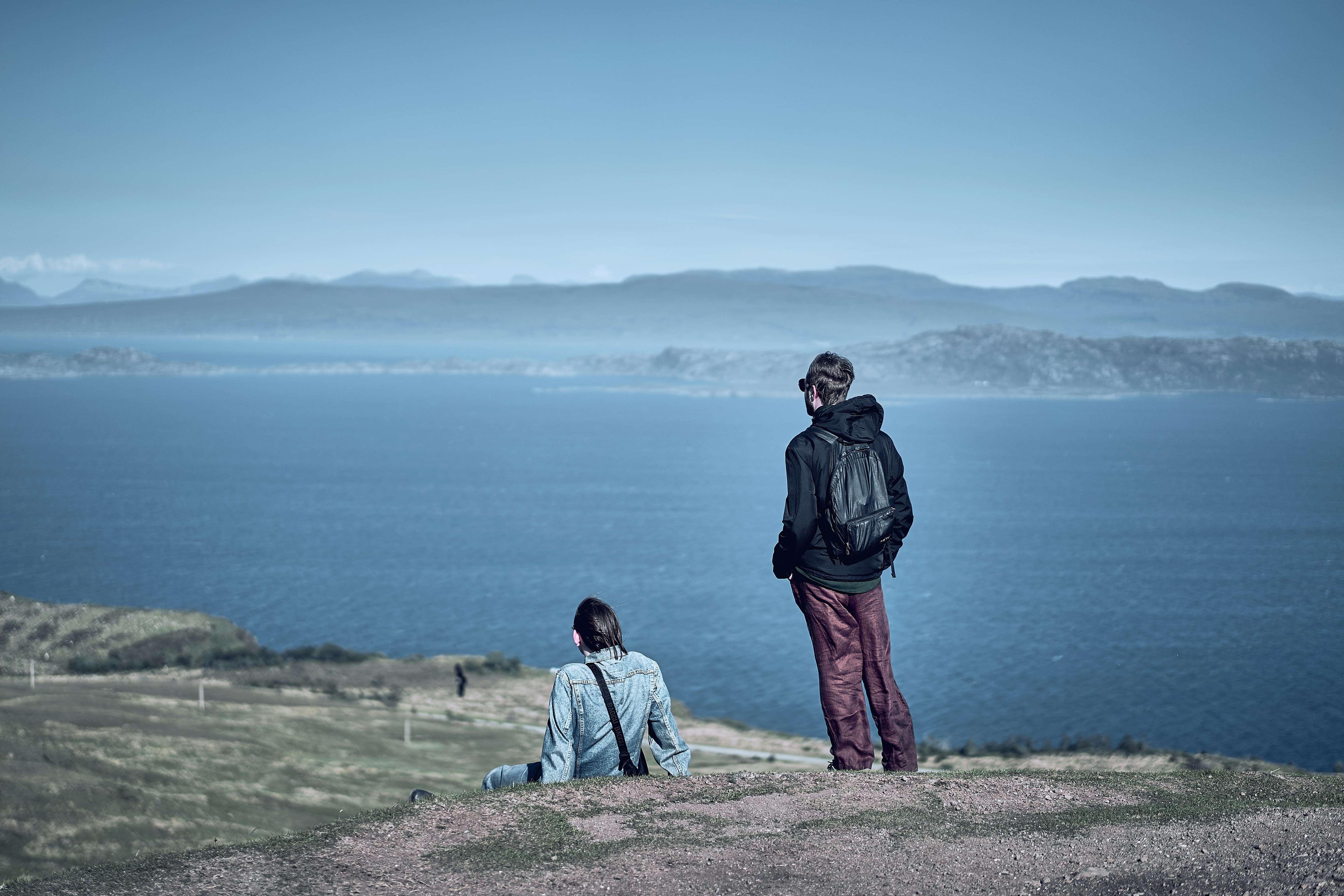 Two Viewers at the Edge: Figures Gazing Toward a Distant Sea Ridge