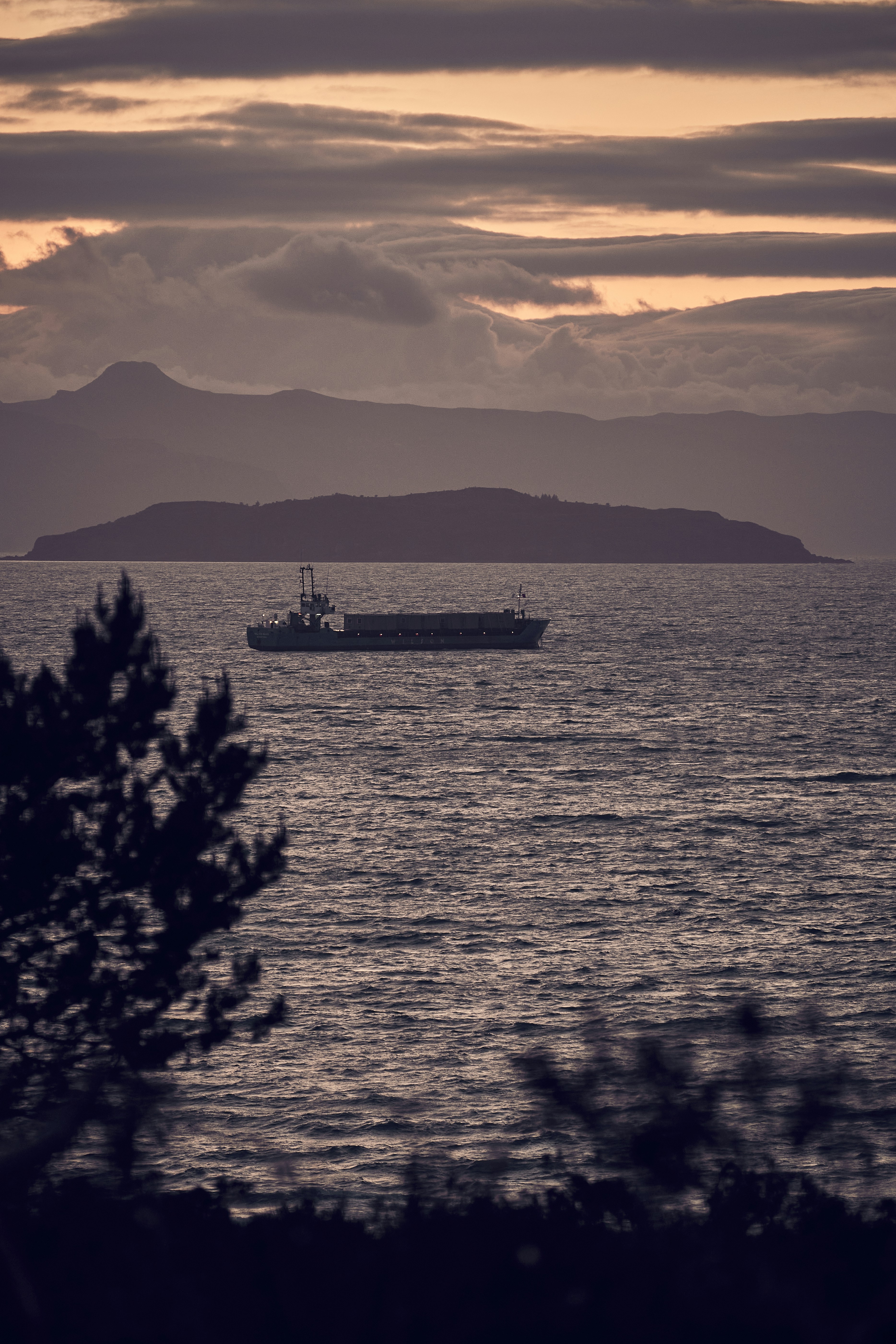 Silhouette Afloat: A Quiet Horizon with a Cargo Vessel at Dusk