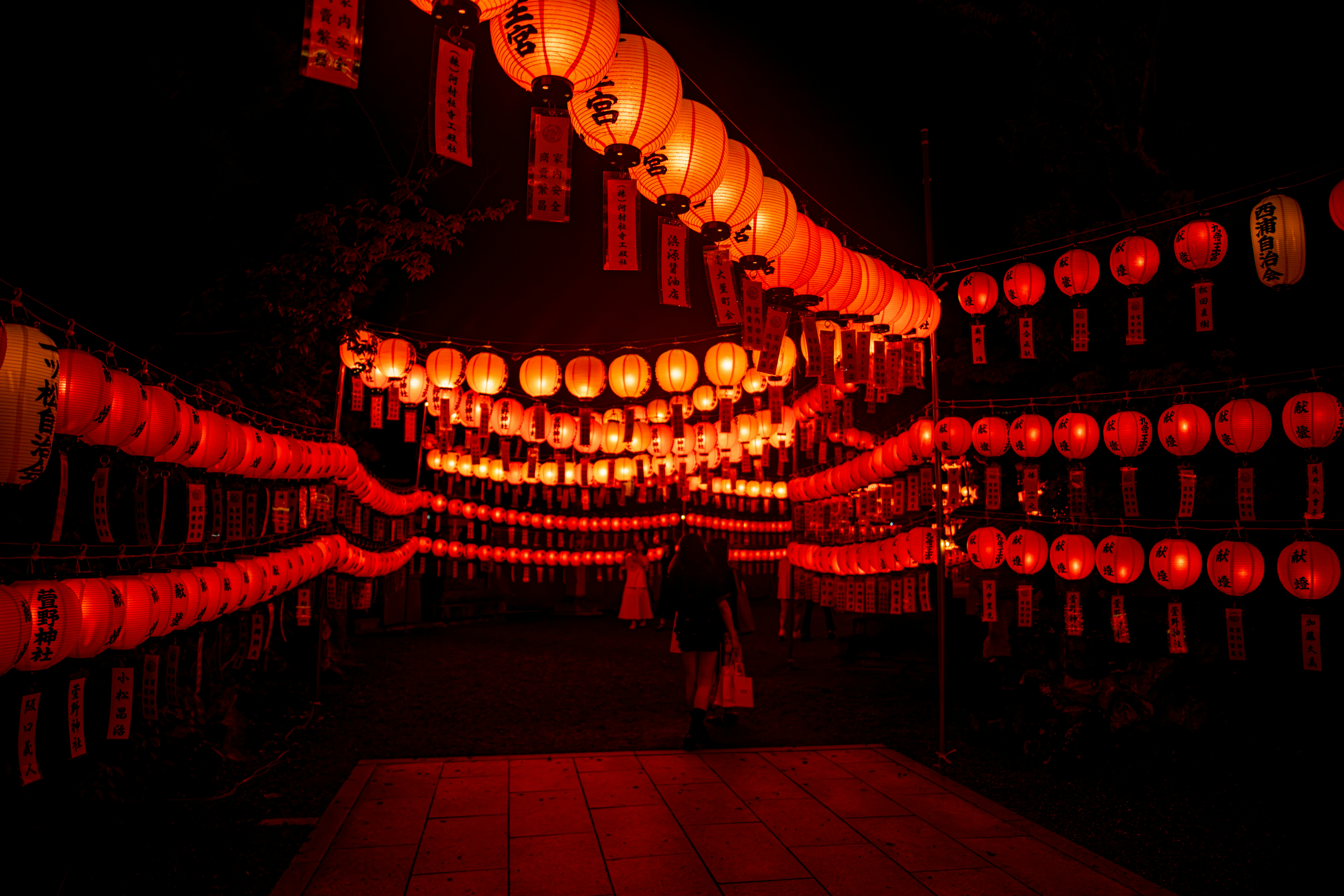 Lantern Pathways: Red Glow Through Night Festival Entrances