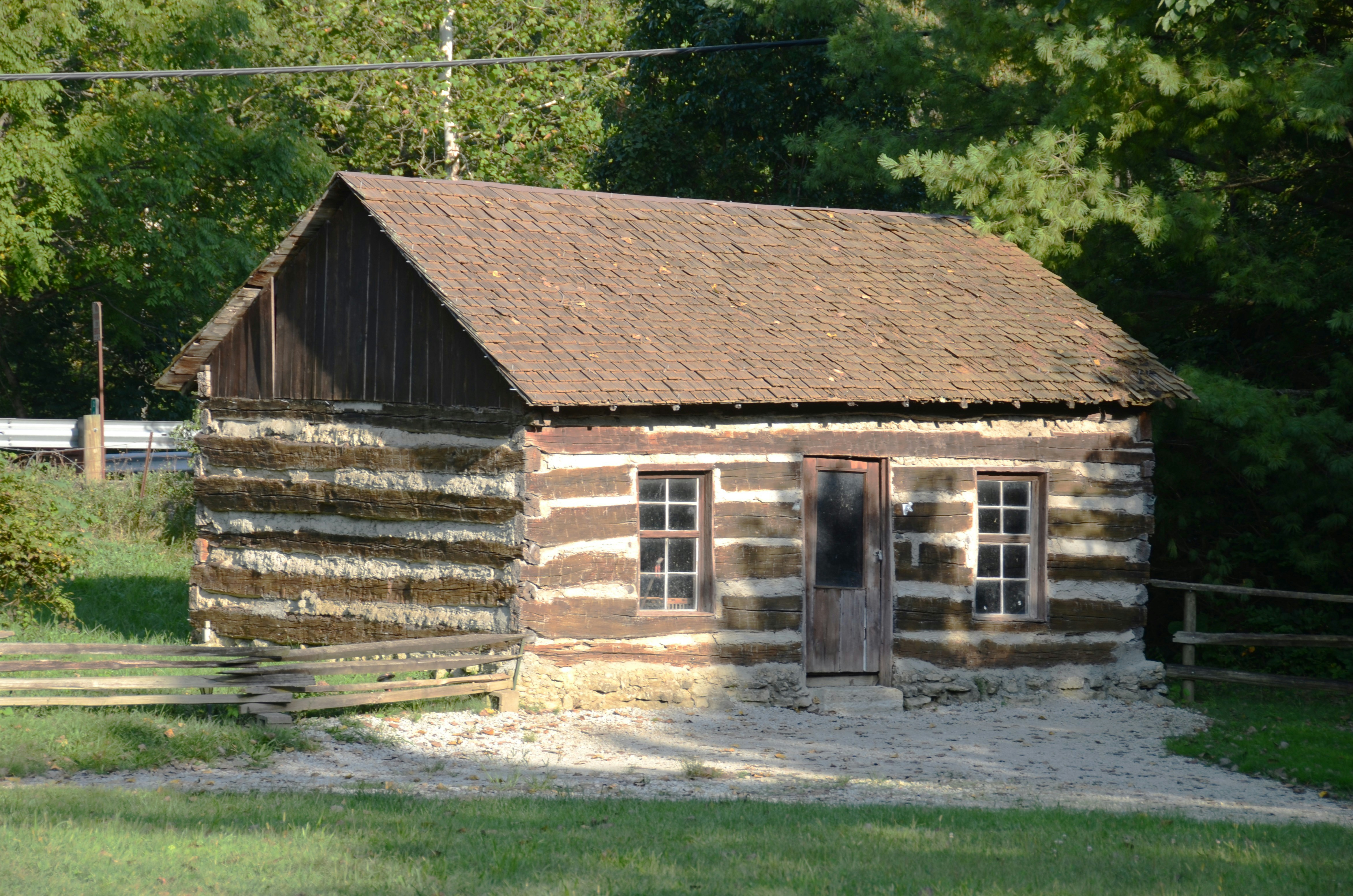 Sunlit Log Cabin with Weathered Roof in a Quiet Clearing