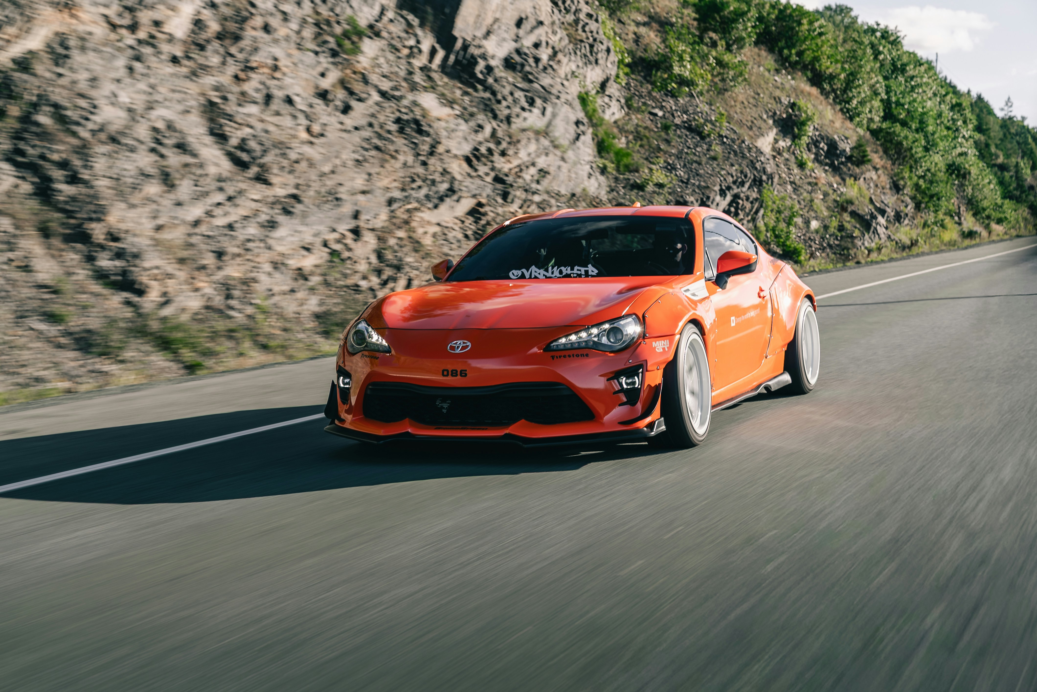 Amber Bullet on the Asphalt: A Bold Orange Sports Car Murmurs Down the Mountain Road