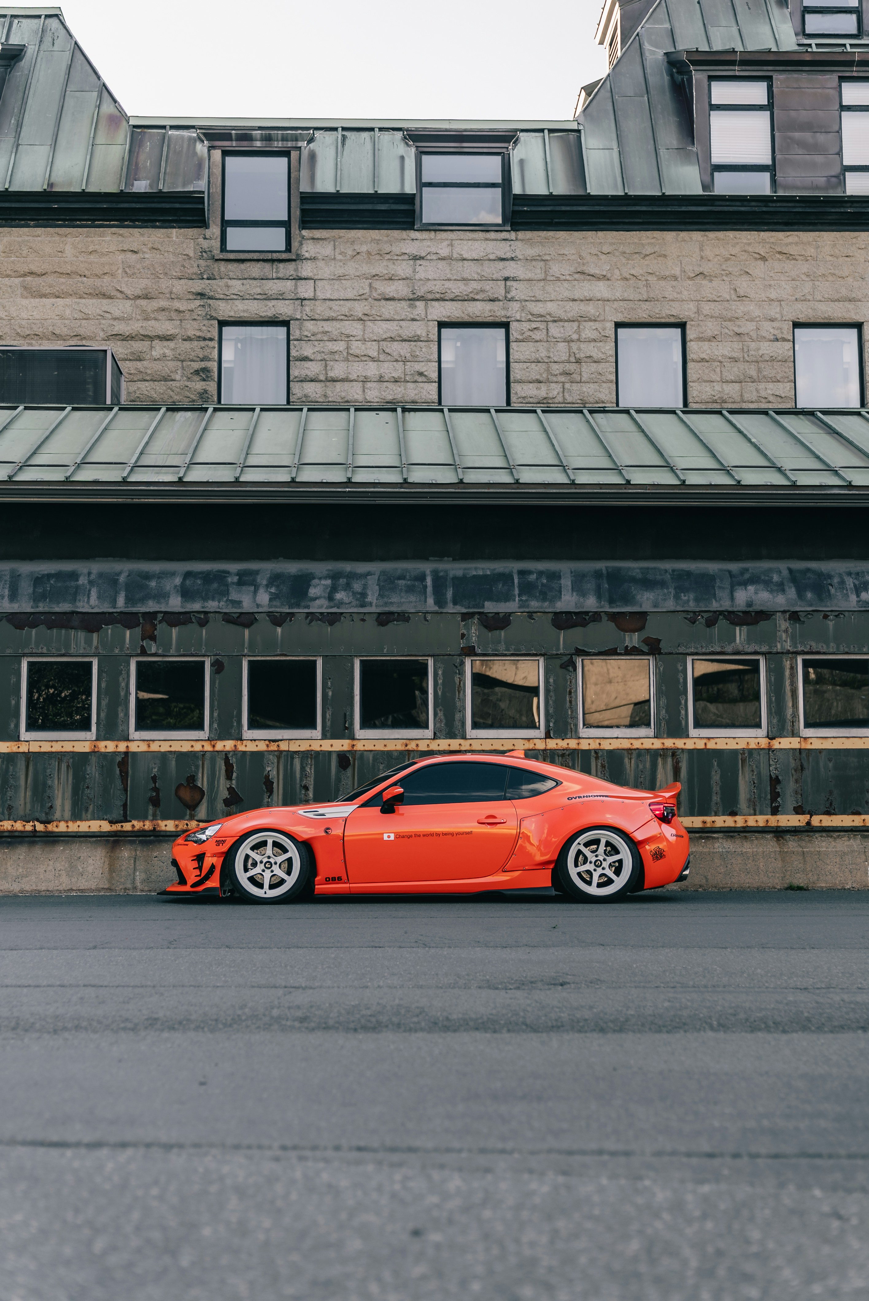 Scarlet on the Street: A Low-Slung Red Tiger by the Factory Wall