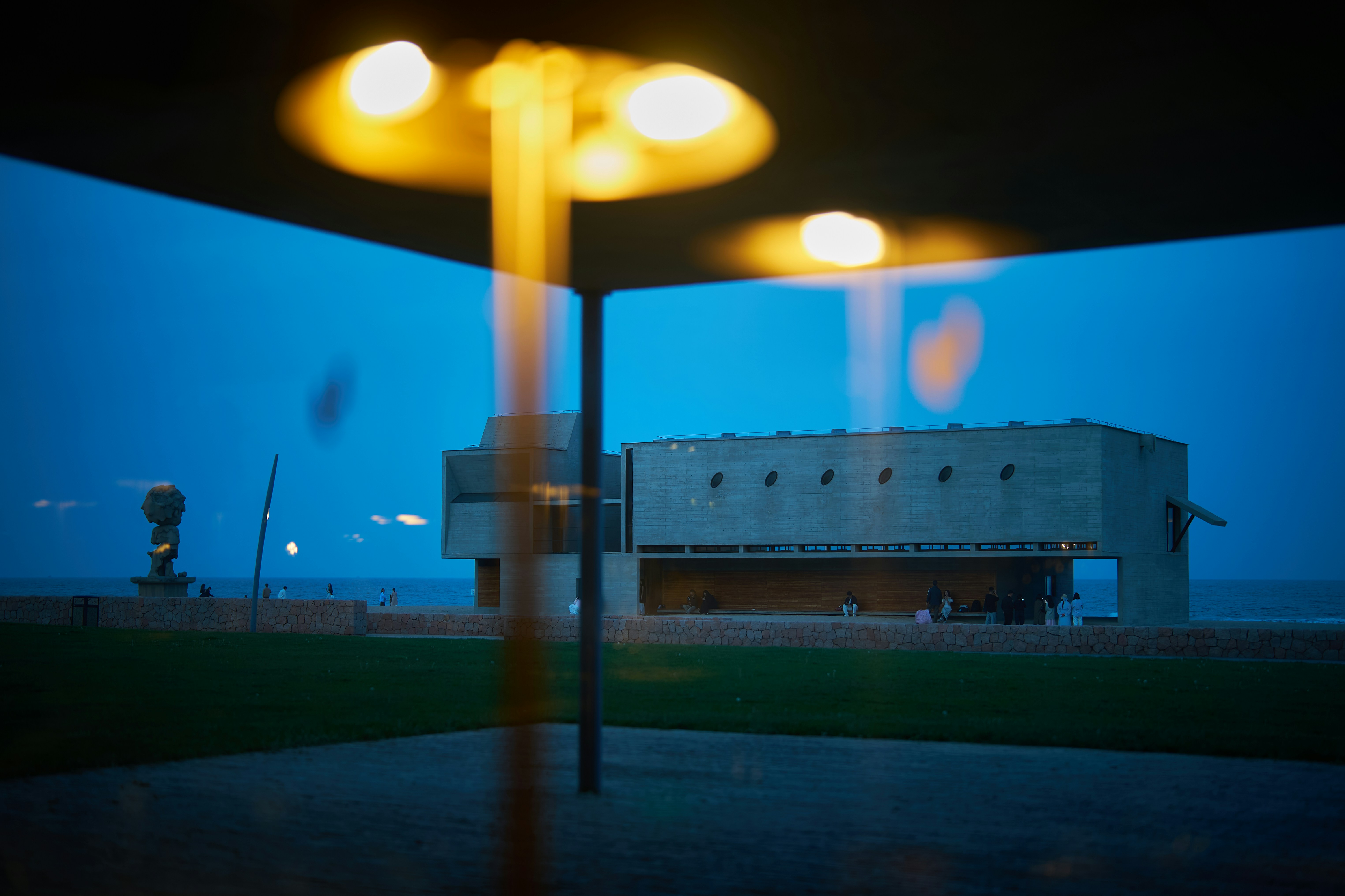 Blue Hour Fortress: An Industrial Building Framed by a Neon-Blurred Window