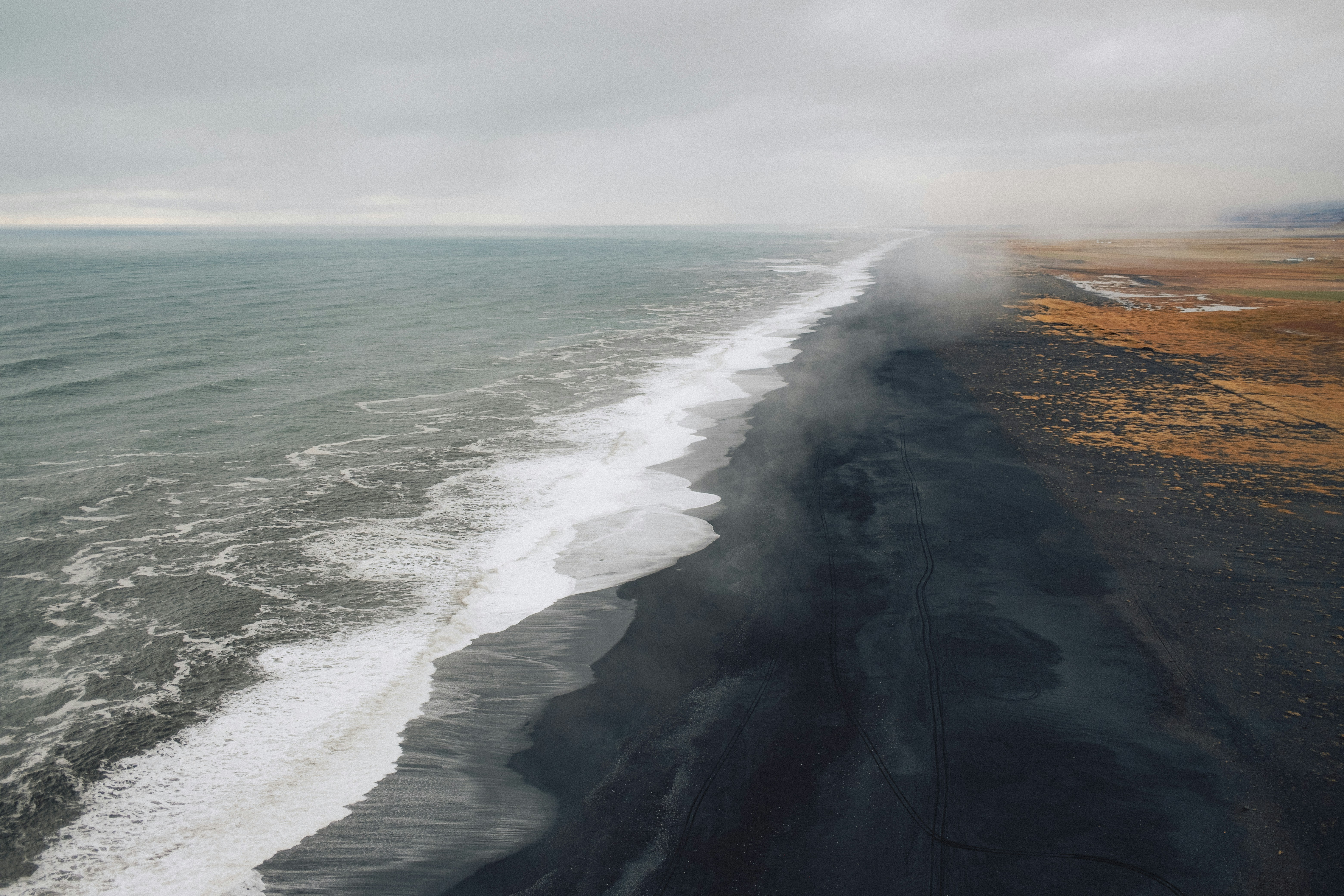 Coastline Confluence: Where Sea Meets Dark Sands