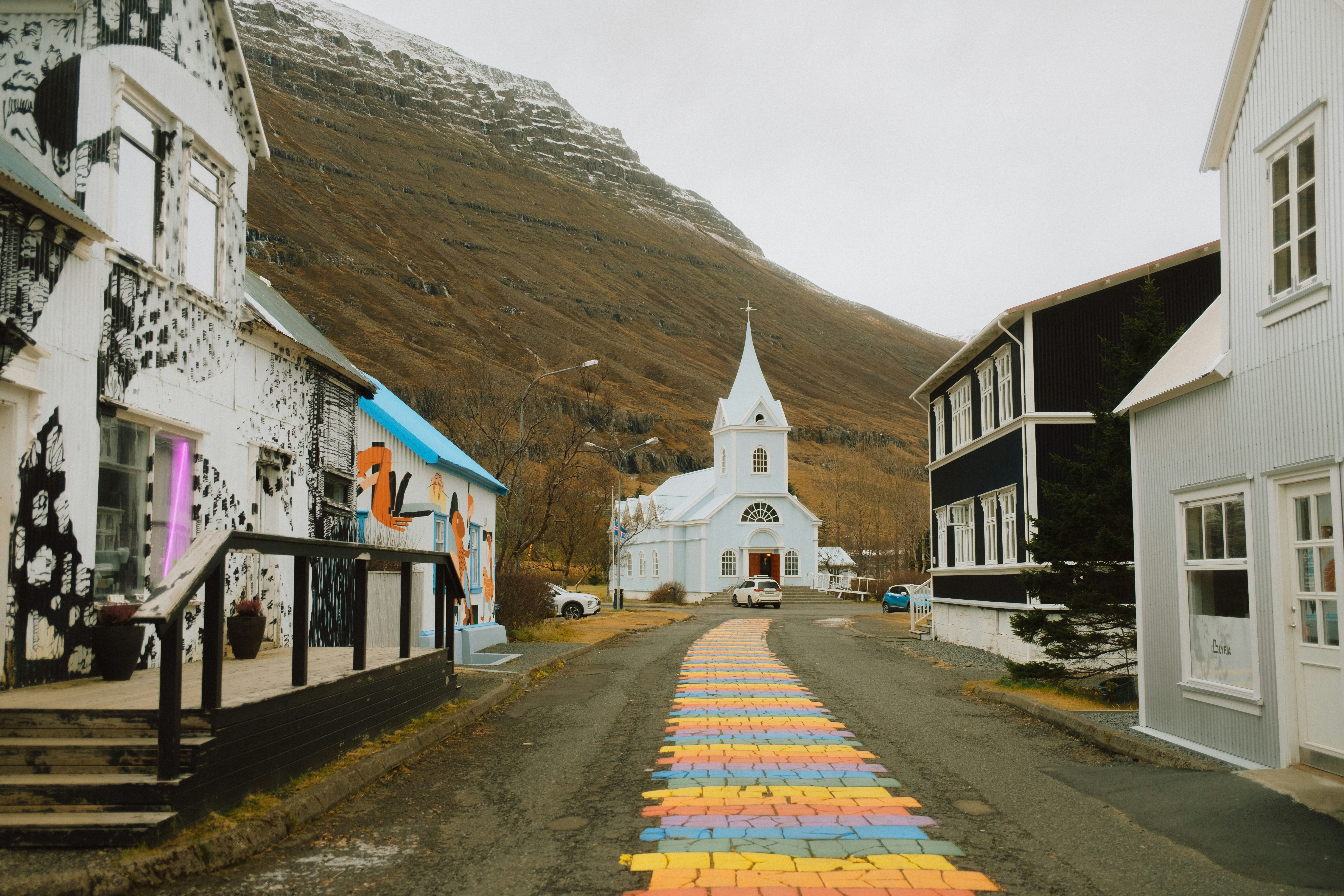 Pastel Crossroad: A Coastal Village Church Framed by Colorful Street