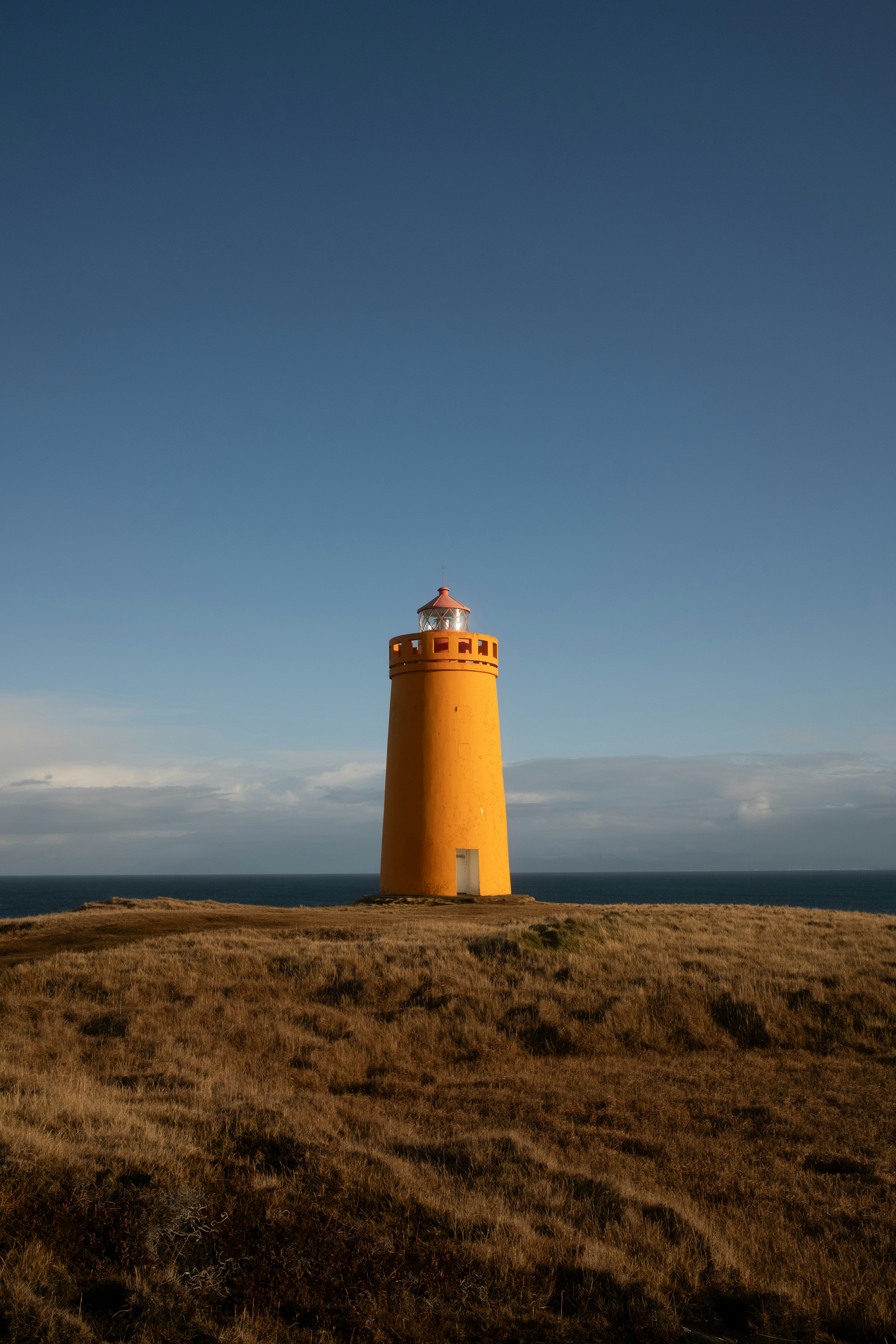 Lighthouse on Golden Hill: A Standalone Beacon Against Open Coastal Sky