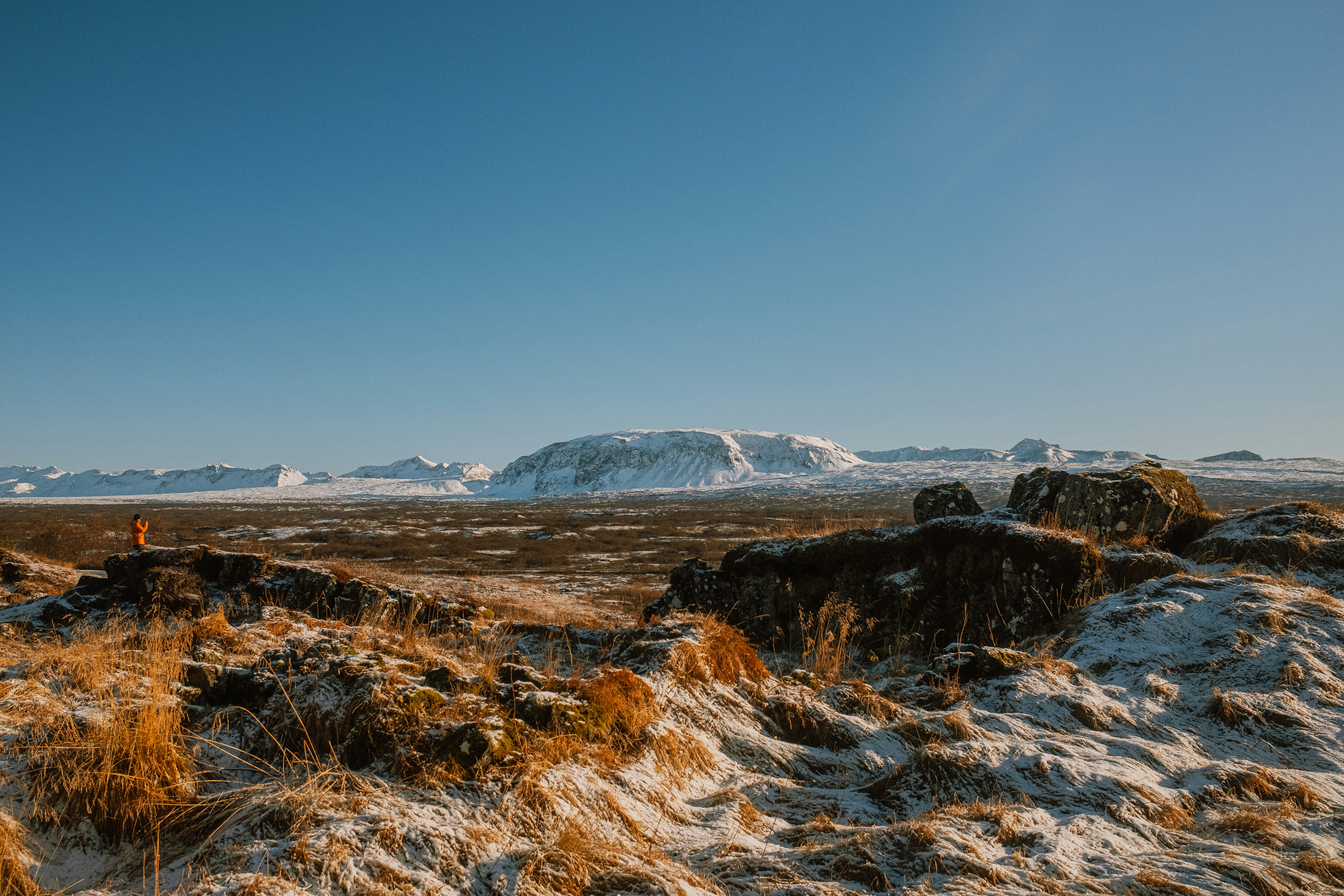 Snow-kissed plains beneath a distant frozen ridge