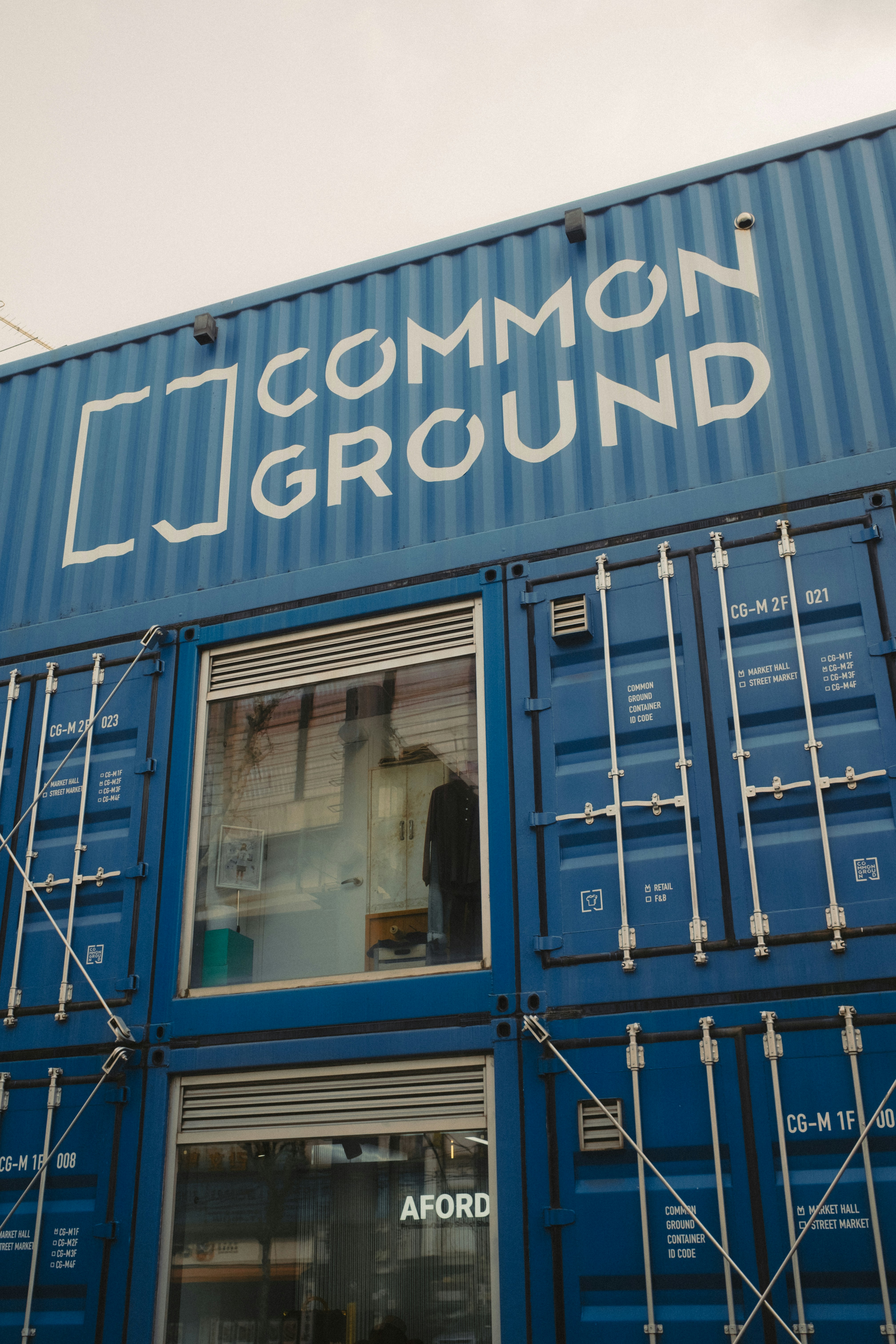 Blue Cargo Oasis: A Freight Container Gallery Under a Painted Sky