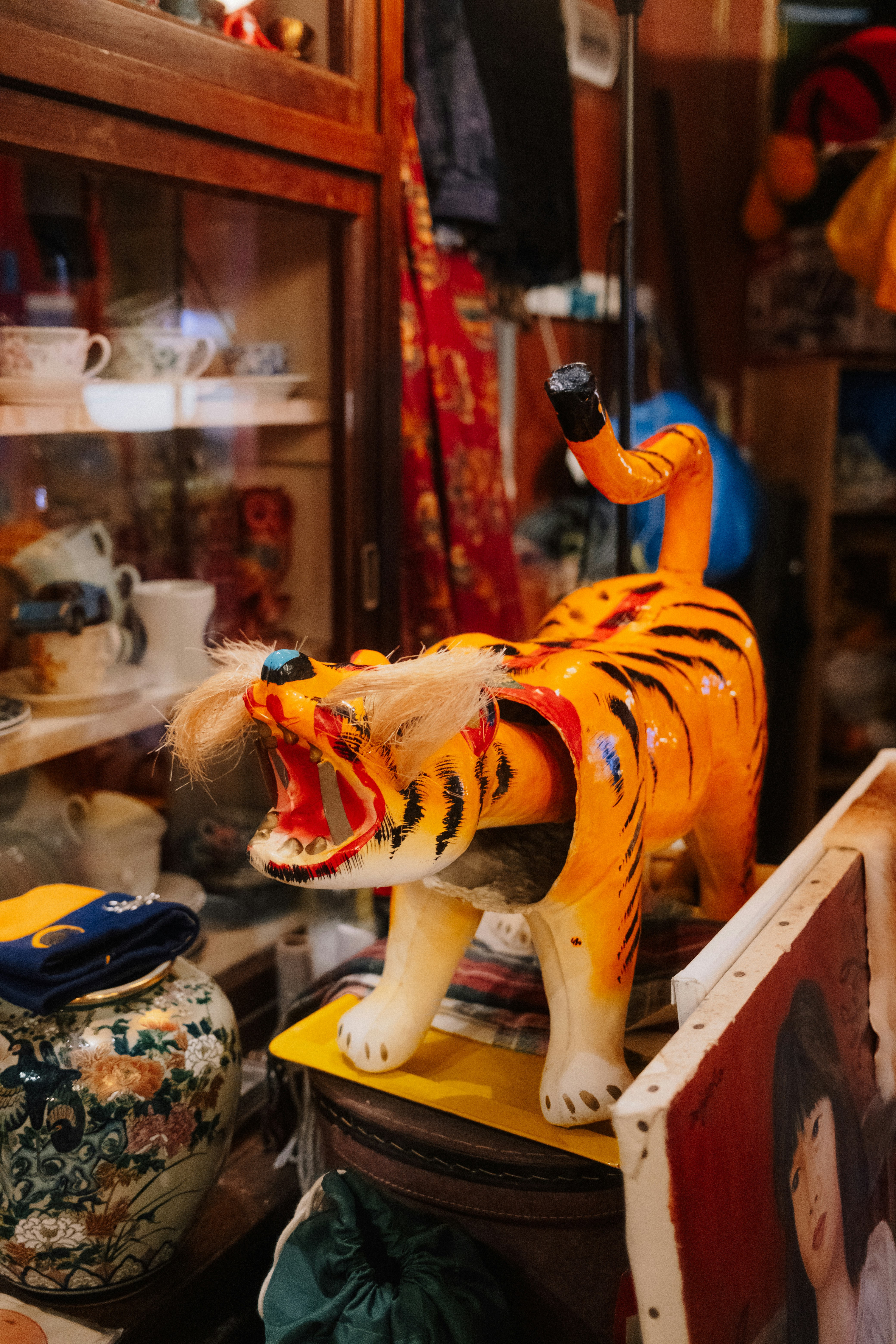 Fiery Tiger on Display: A Vintage Shop Figurine Amid Domestic Treasures