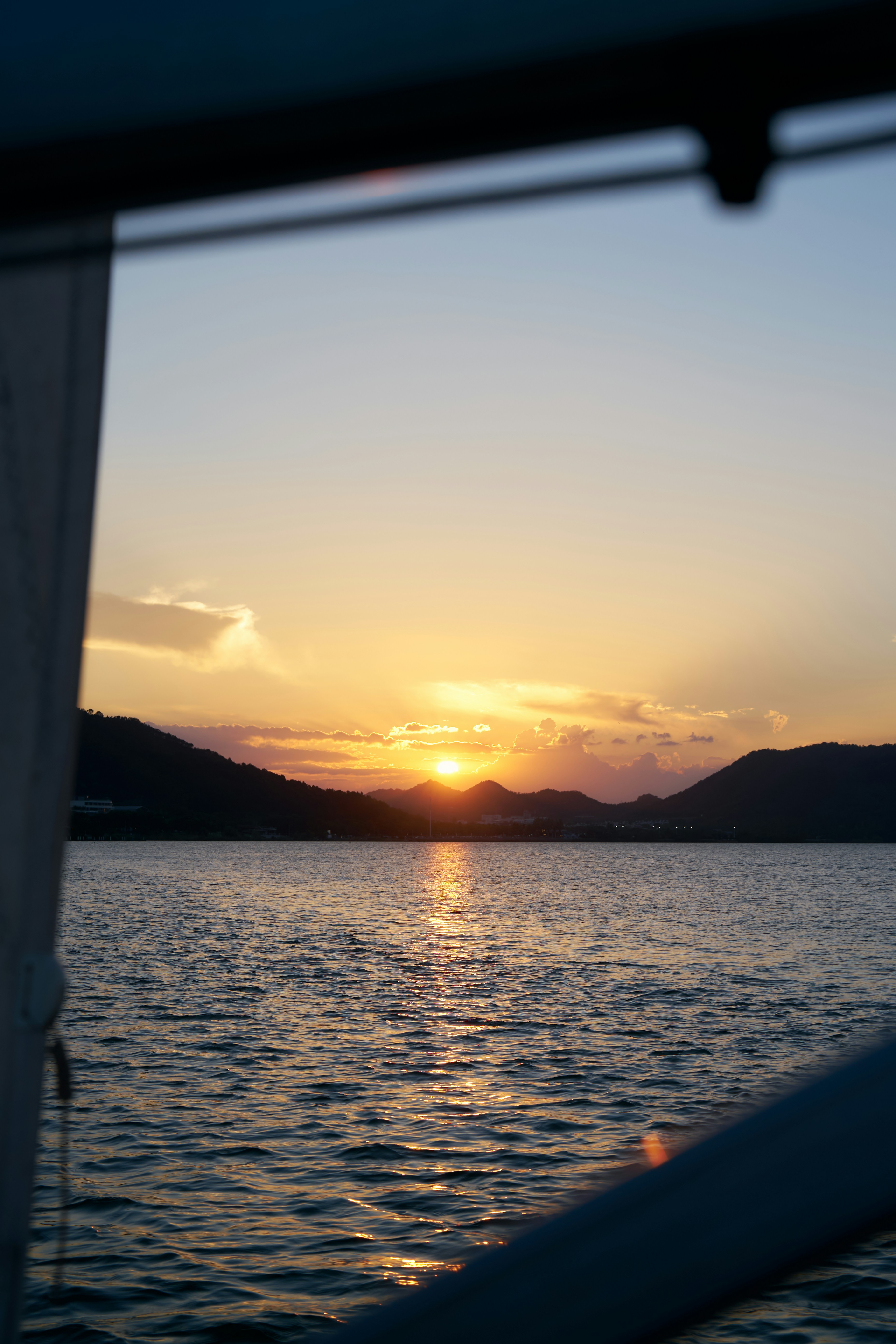 Sunset Through a Boat Window: Quiet Horizon Over Calm Waters