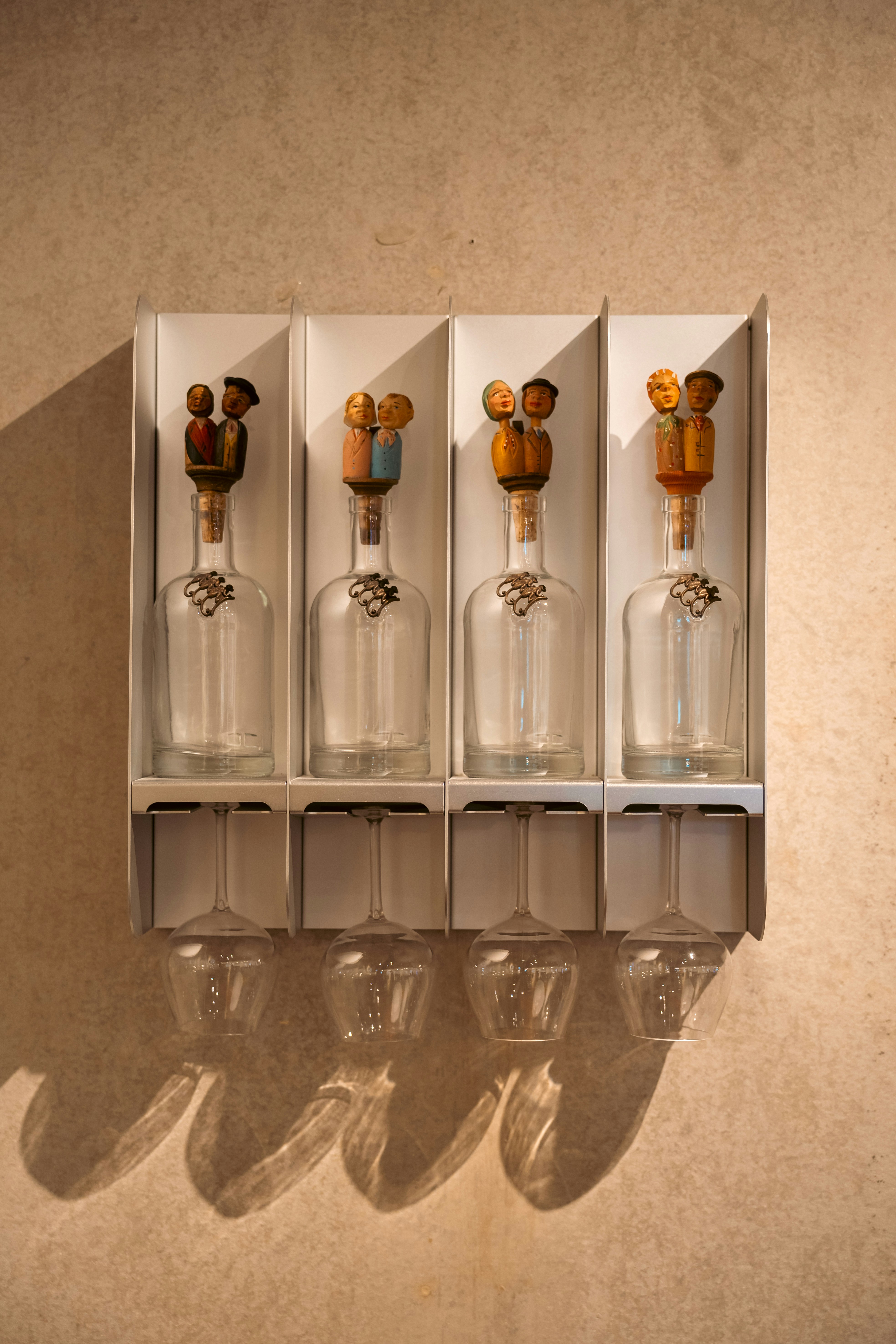 Wineglass Quartet: A Row of Bottled Figures Cast in Warm Light