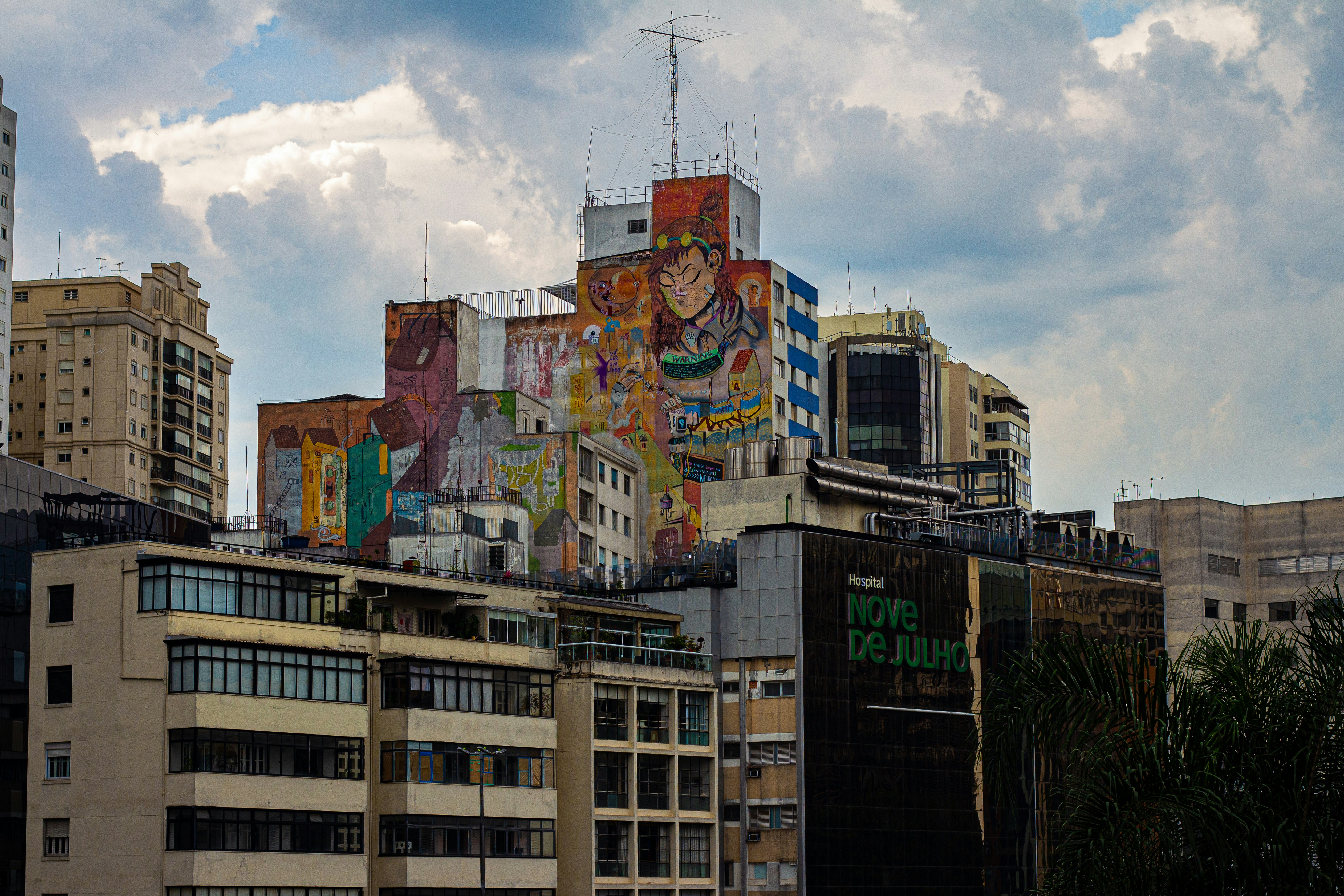 A mural-topped skyline: colorful building art anchors a dense urban silhouette