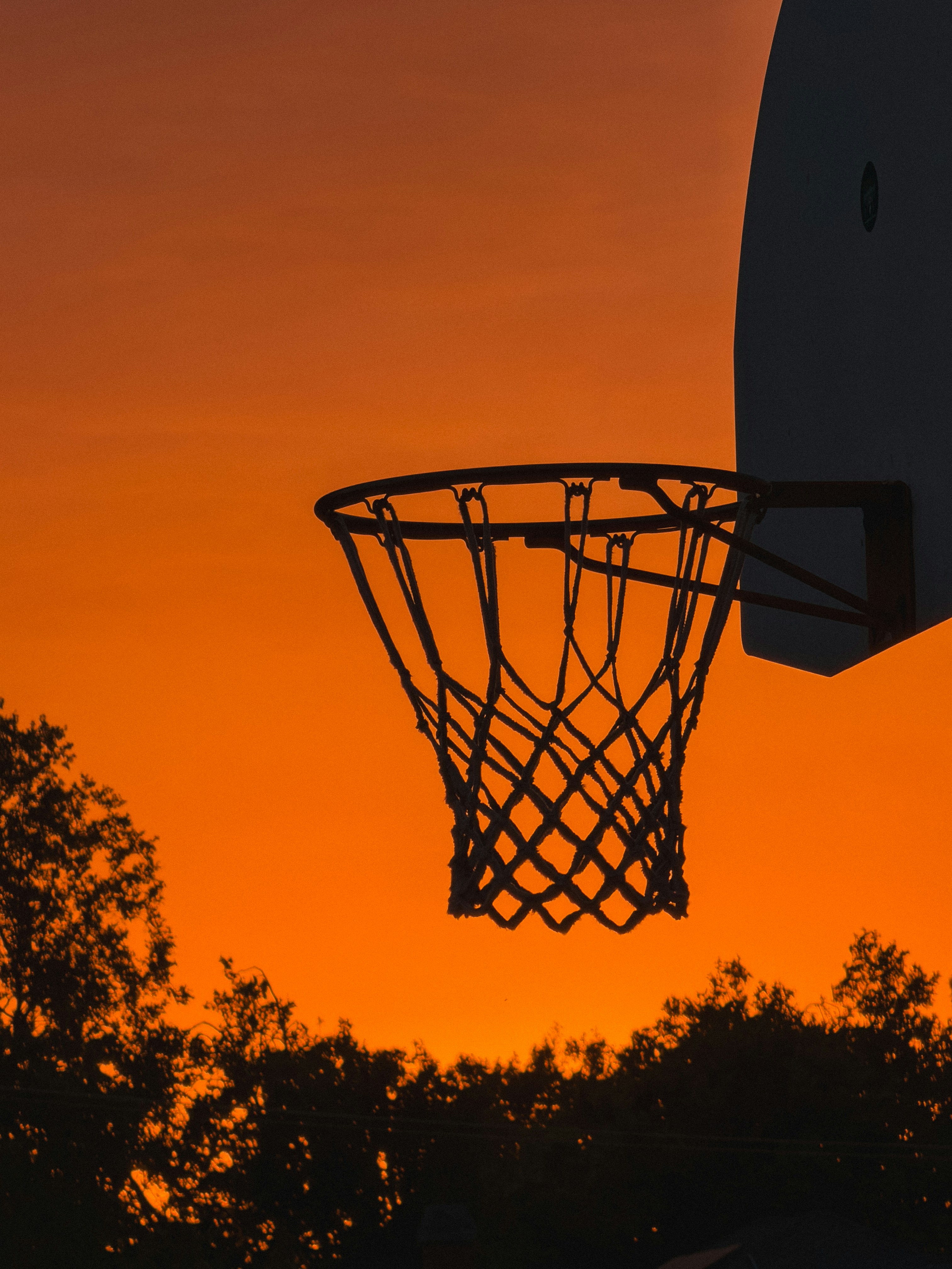 Basketball Hoop Silhouette Against a Fiery Sunset