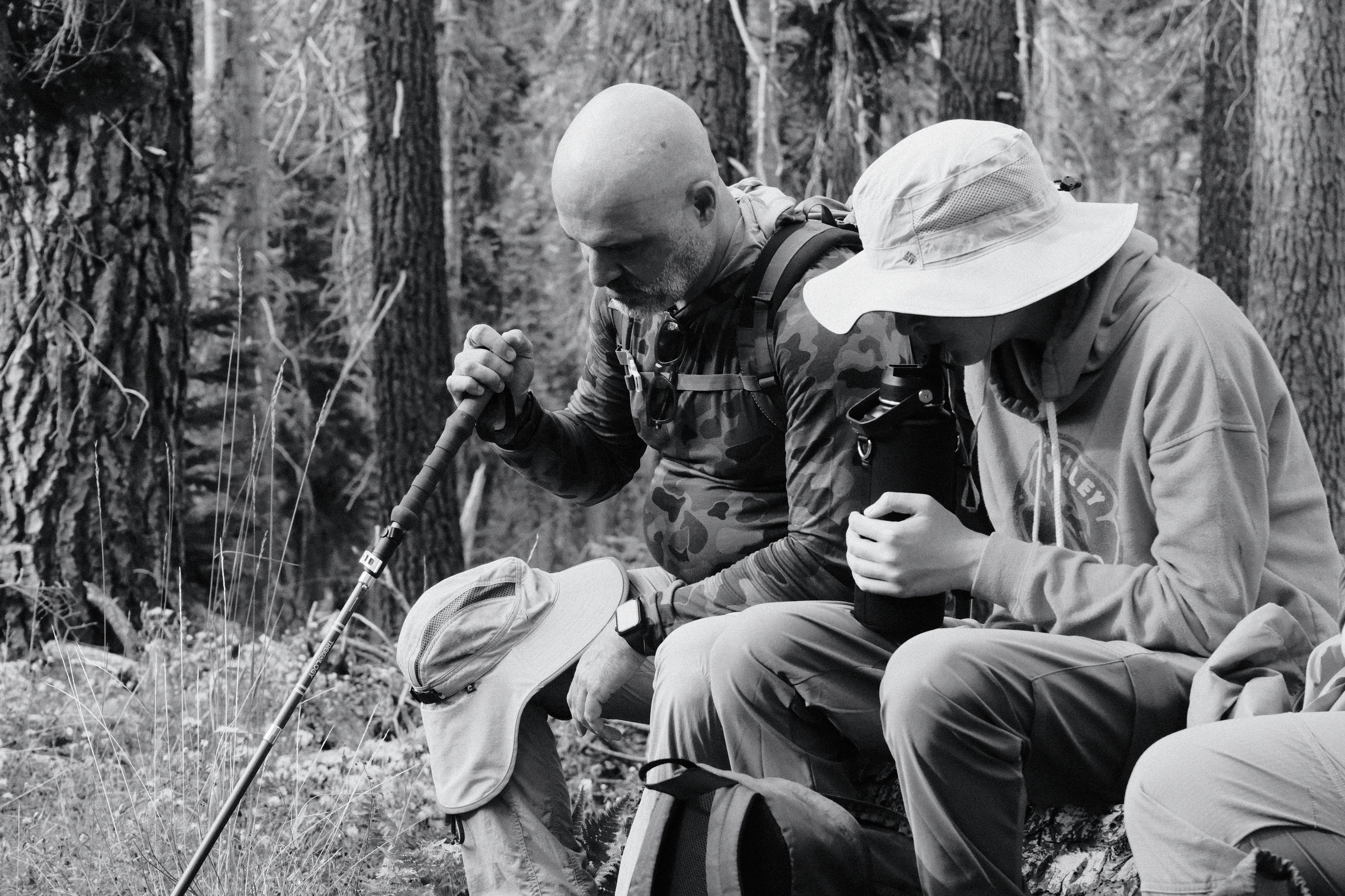 Quiet Pause in the Pines: Two Hikers Resting Under a Forest Canopy