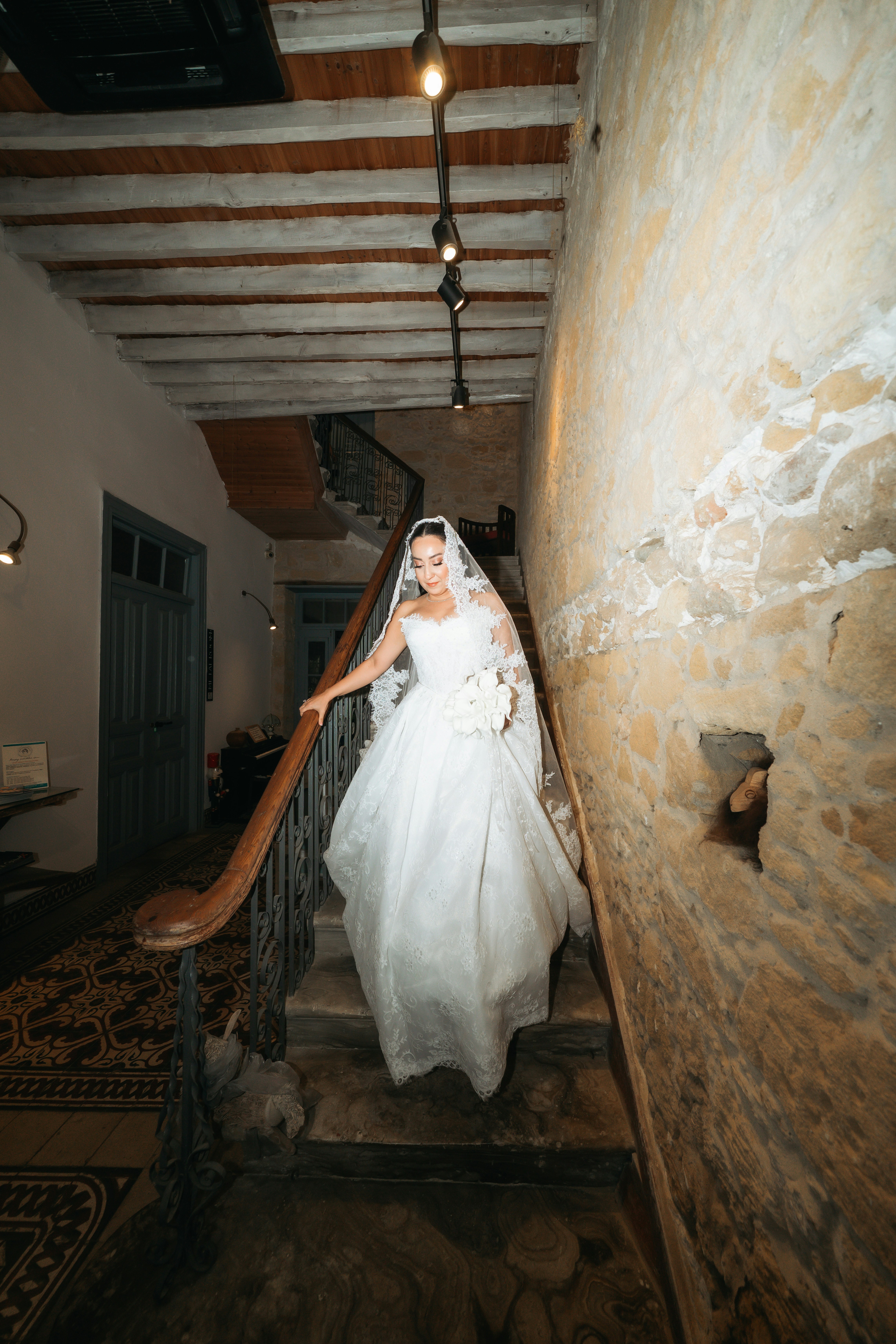Bride Descends a Velvet Stairway: A Moment of Quiet Grace
