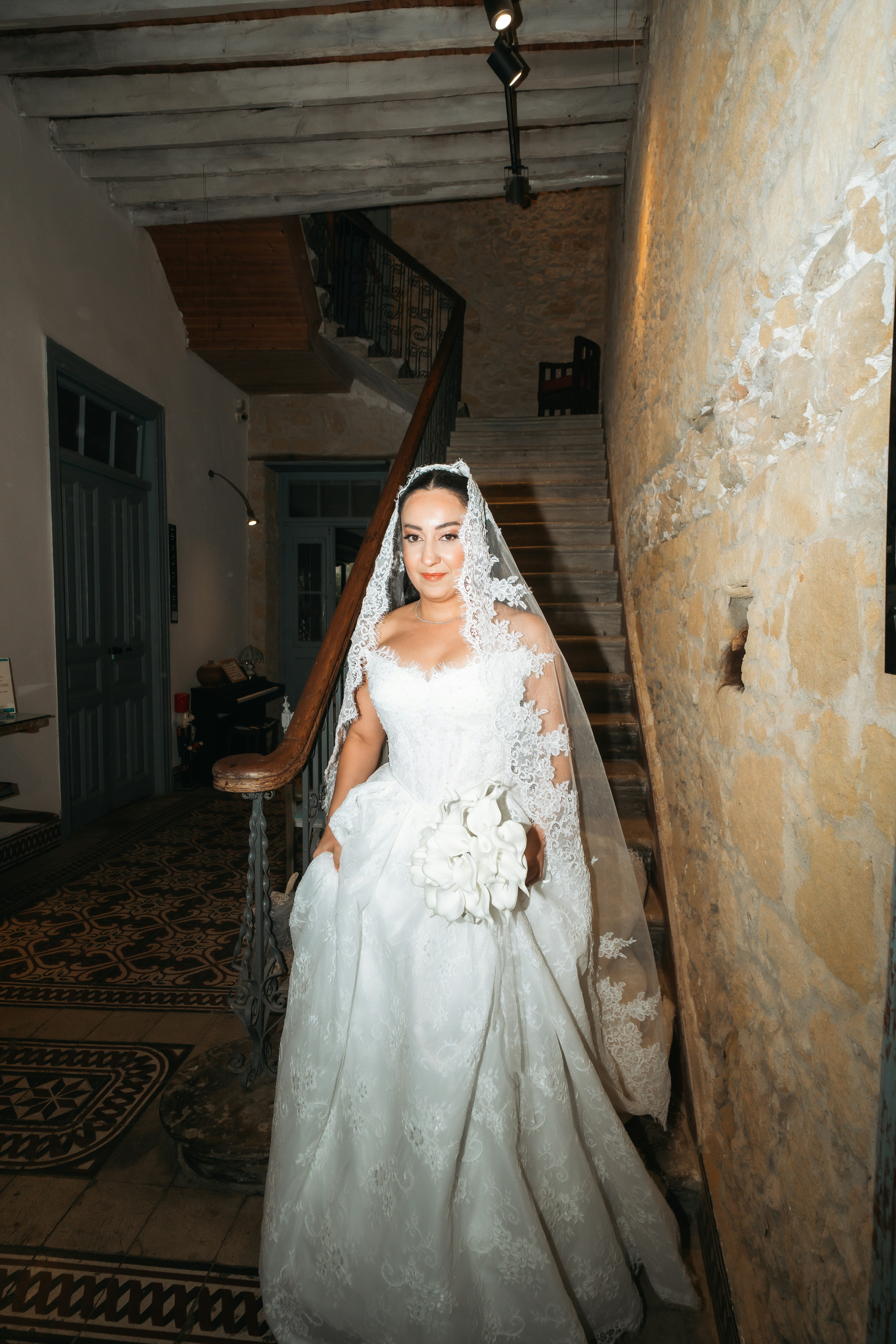 Bride in Lace: A Contrast of Ivory and Stone in a Stairwell Moment