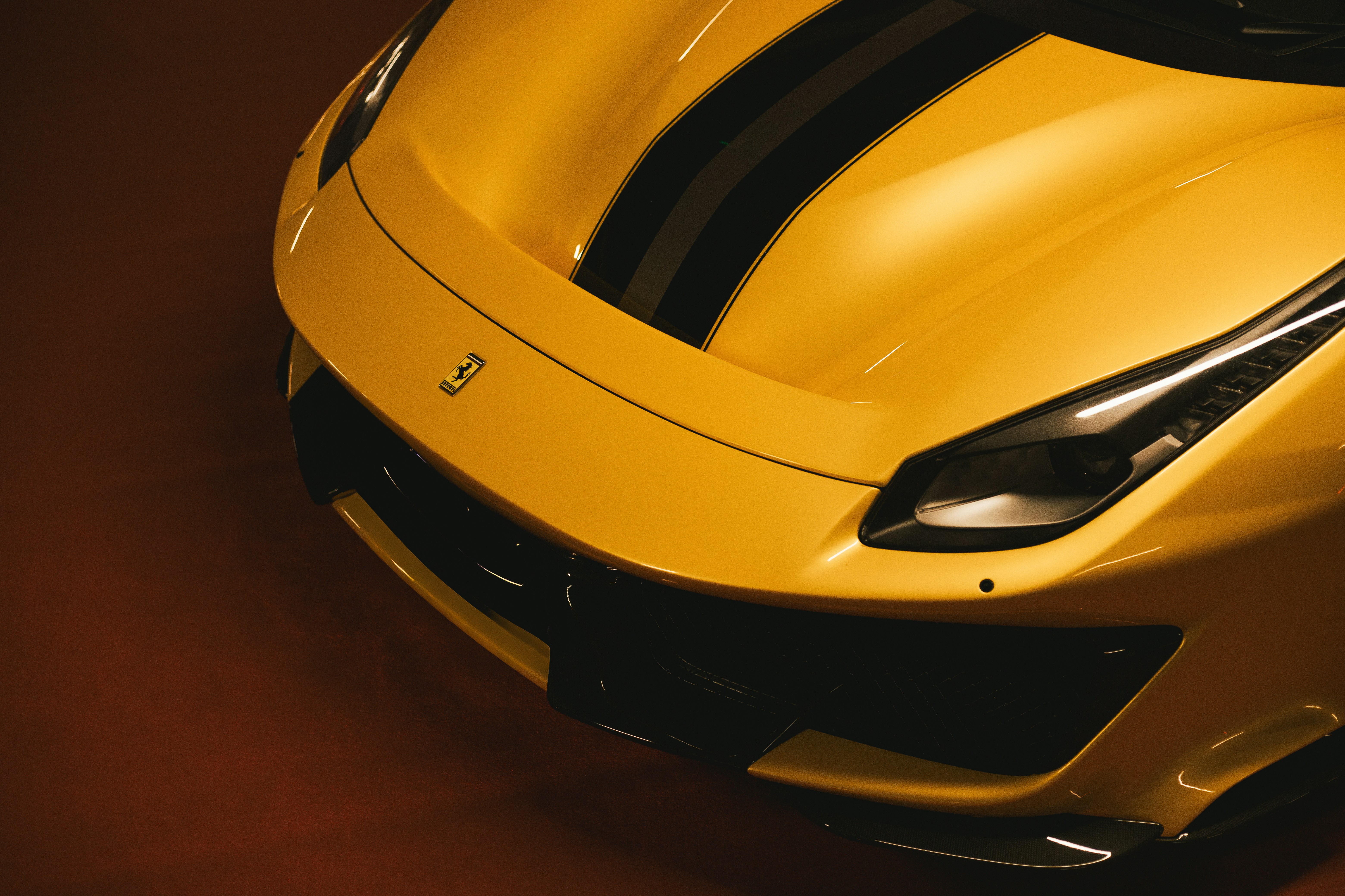 Golden Roar: Front Hood and Headlight Perspective of a Ferrari