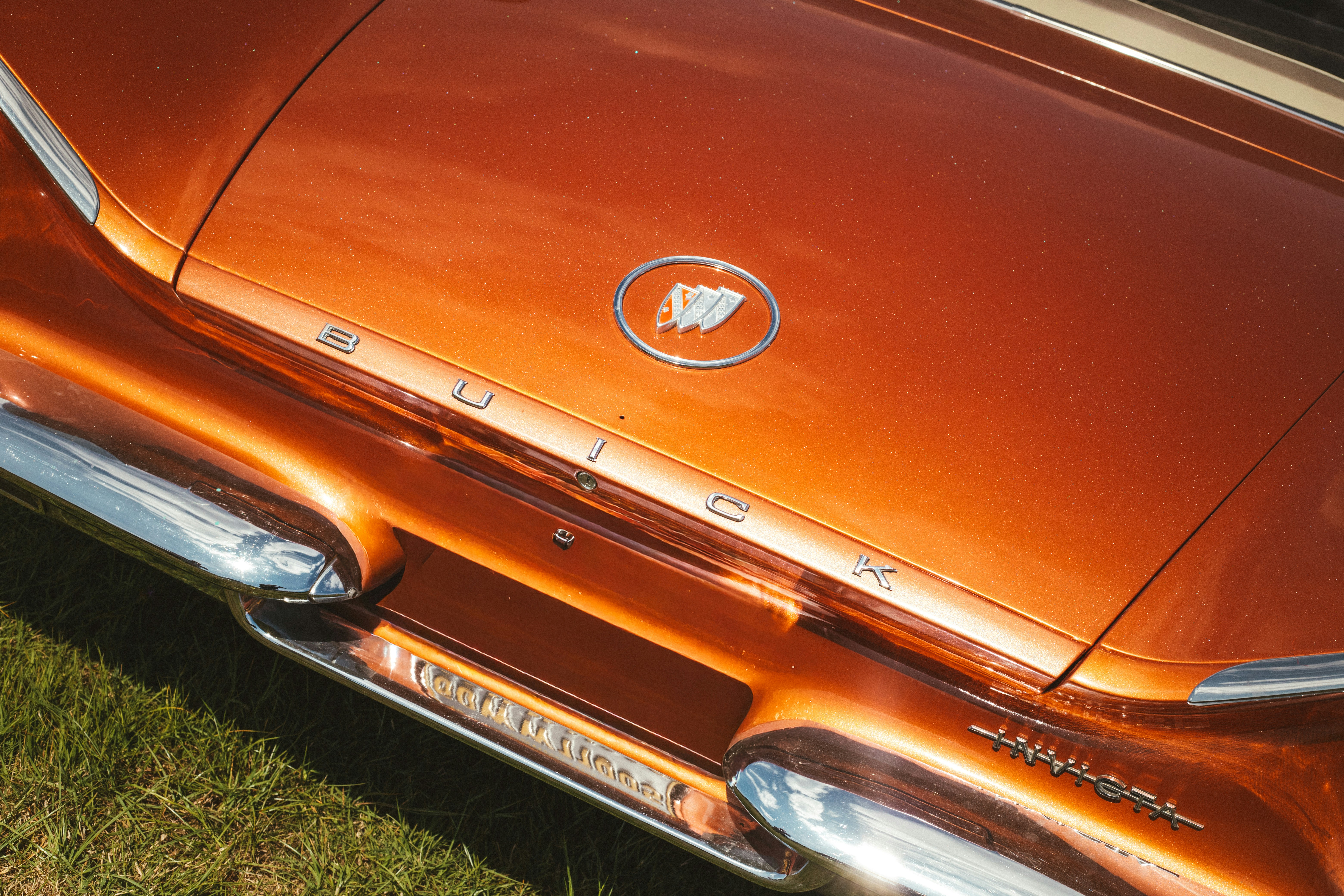 Copper-orange Buick Crest: A Vintage Chrome-and-Badge Close-up