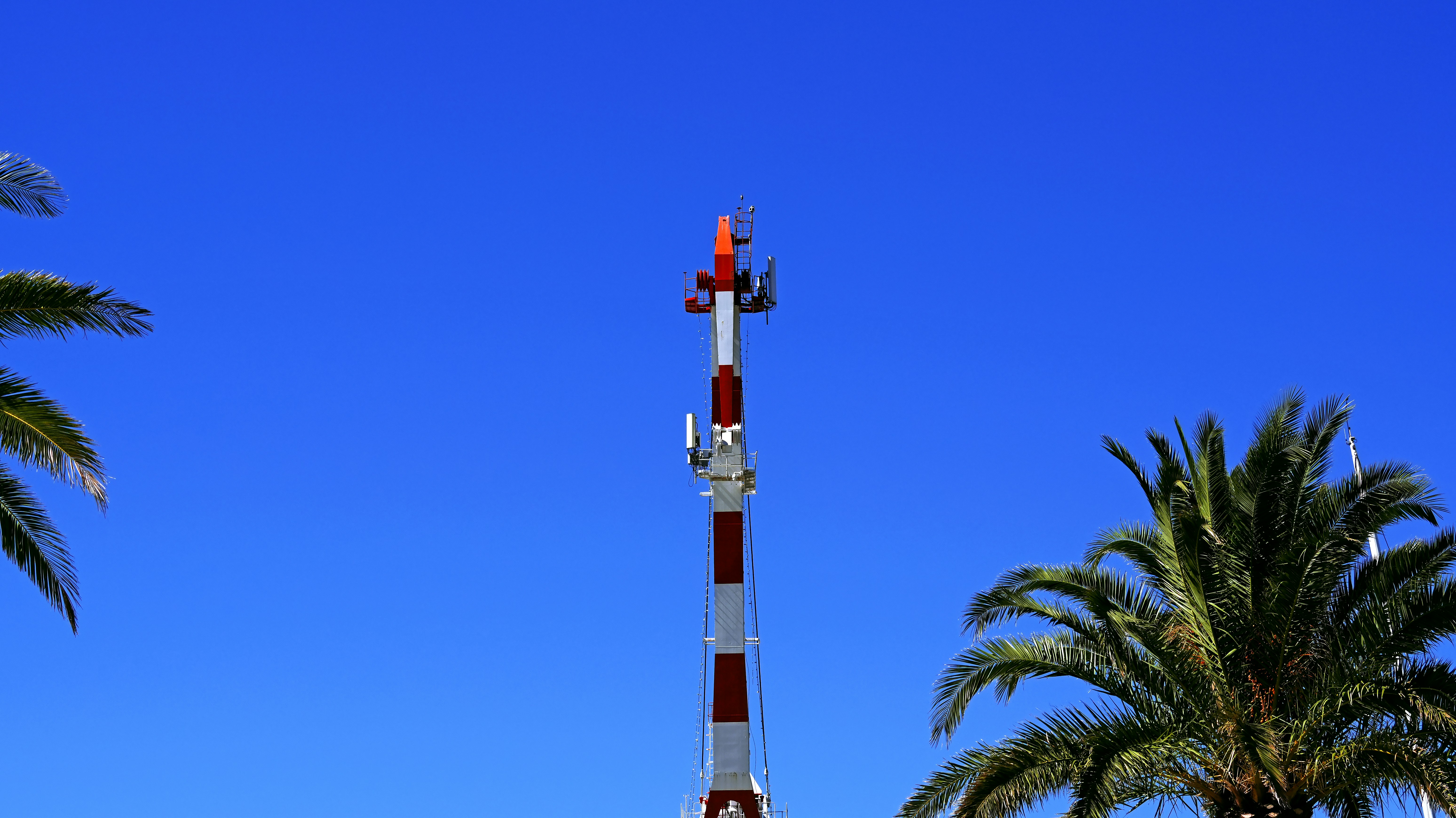 Tall Red-and-White Mast Reaching Toward a Clear Sky