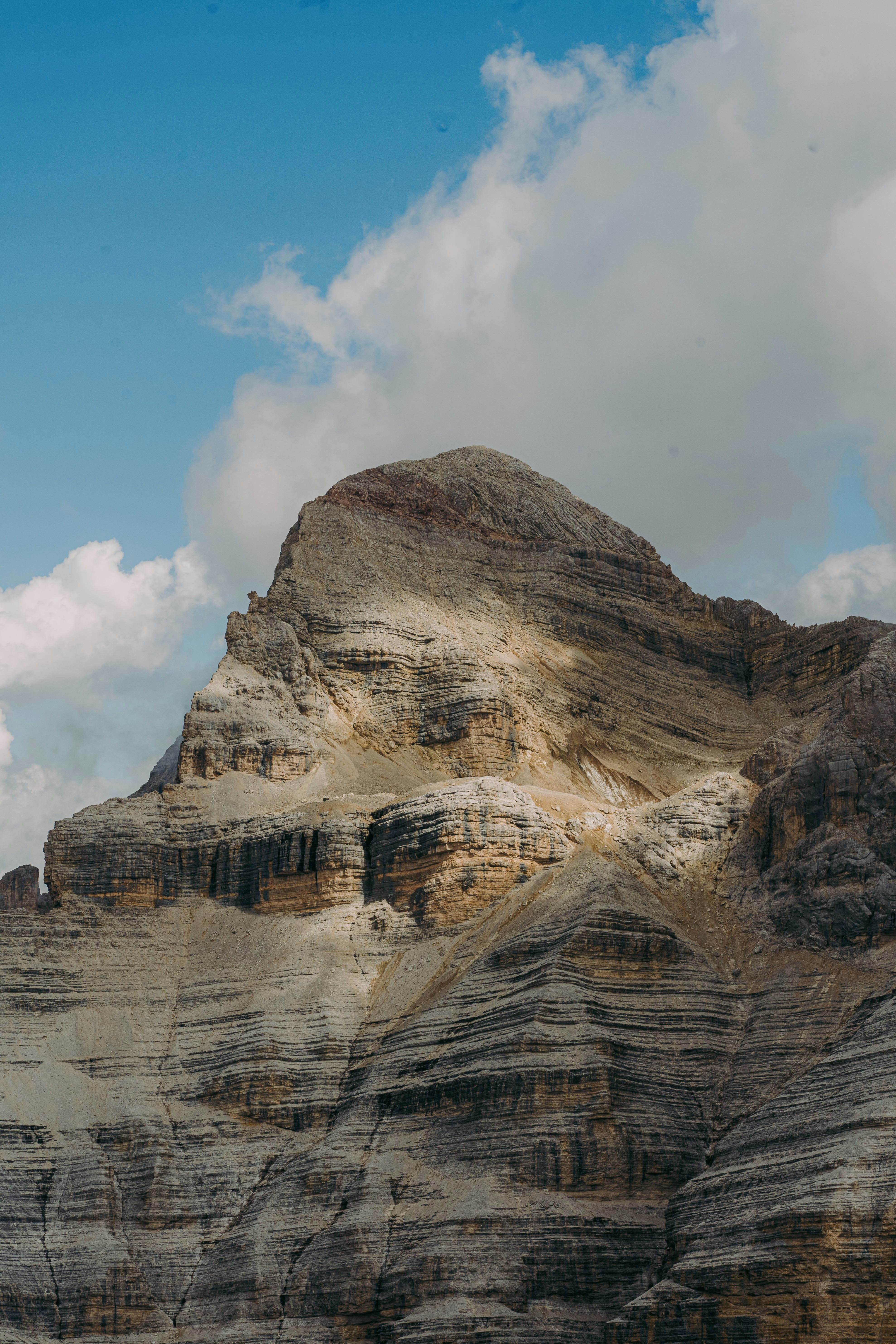 Granite Crown: Weathered Strata Rise to a Clouded Peak