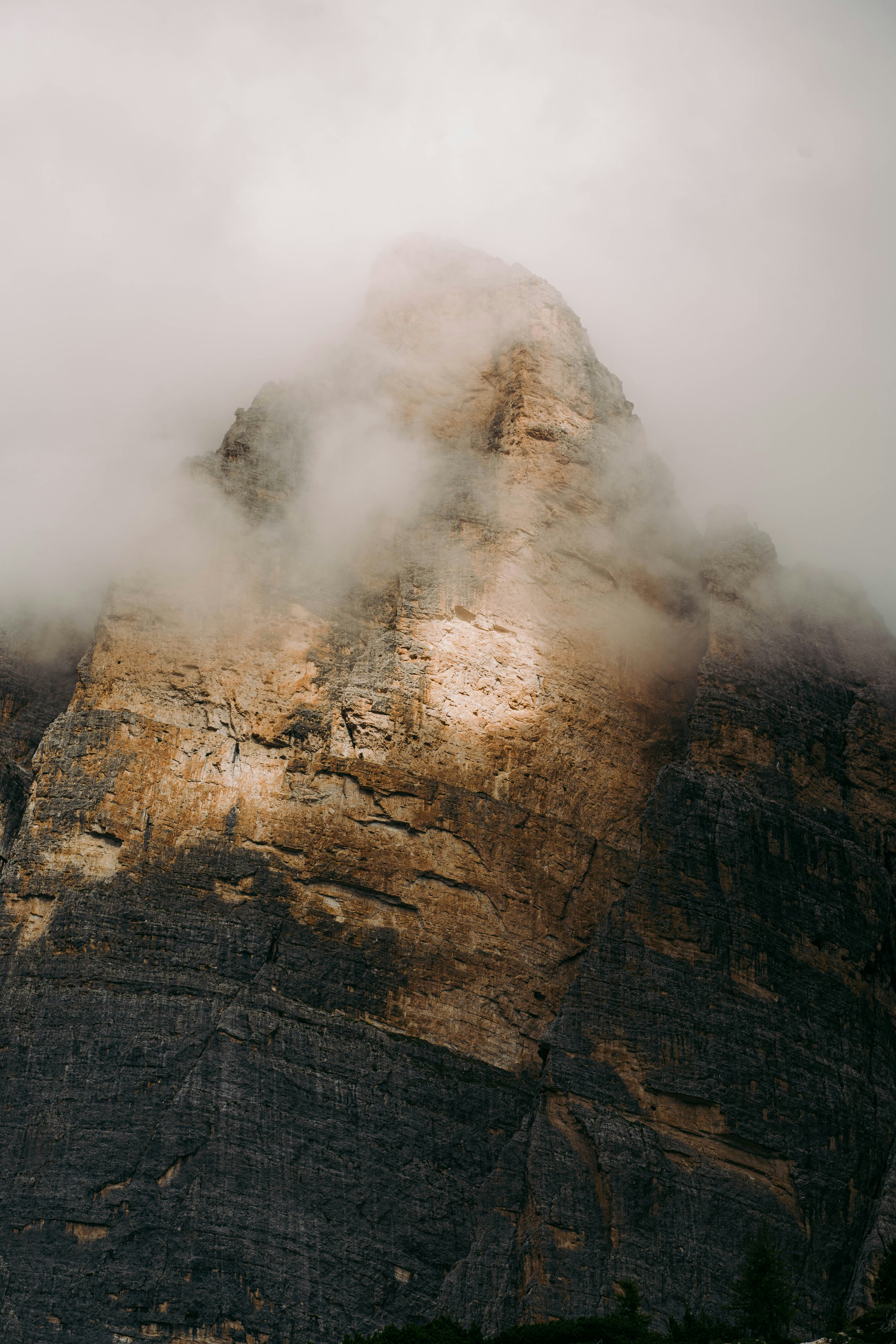 Mist-Wedged Peak: A Towering Summit Rising Through Soft Clouds