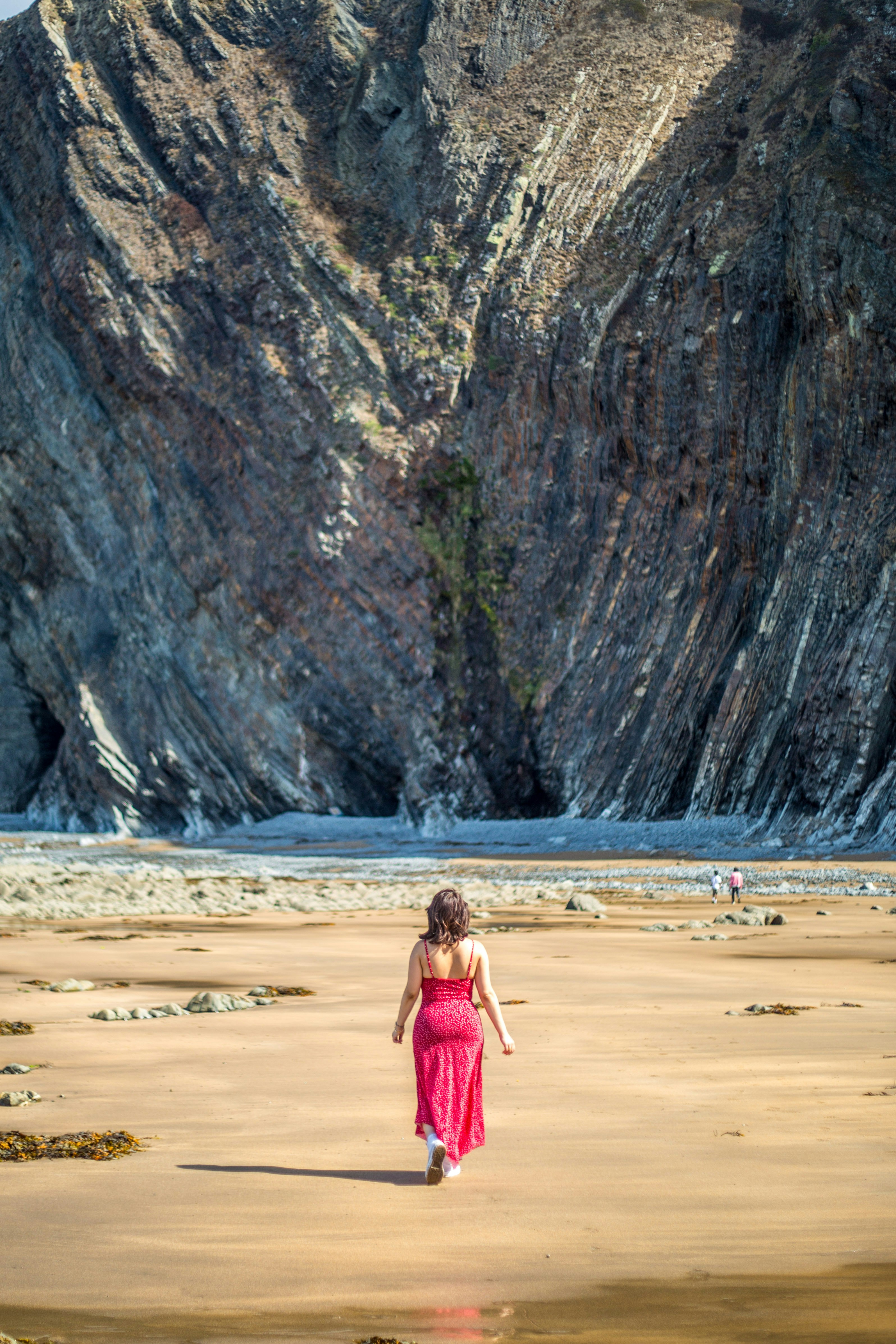 Red dress, blue sea walls: solitary wanderer at the canyon shore