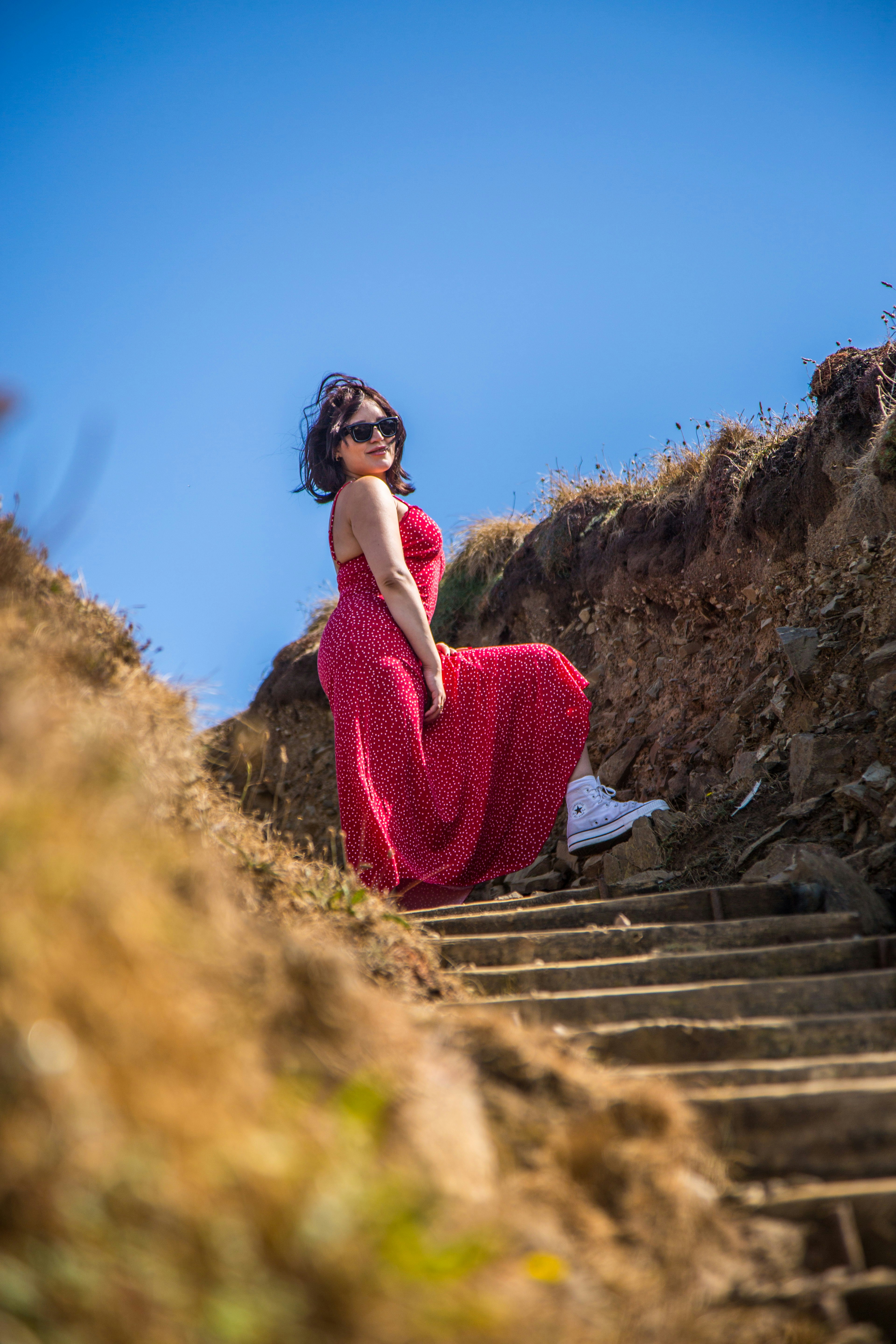 Red Dress on the Edge: A Moment Among Cliffside Steps