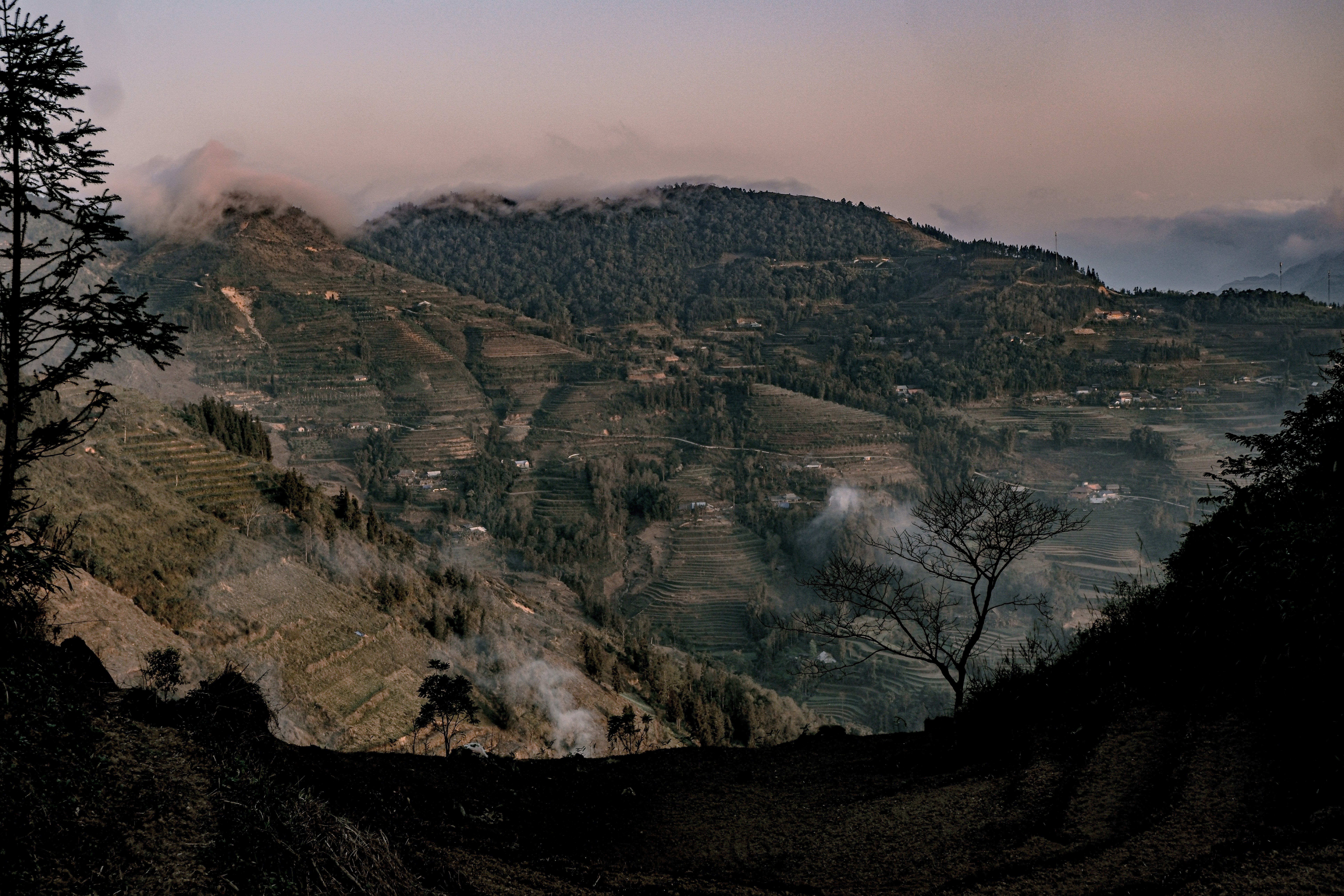 Terraced Valleys at Dawn: Smoke Lifts Over Contoured Hills