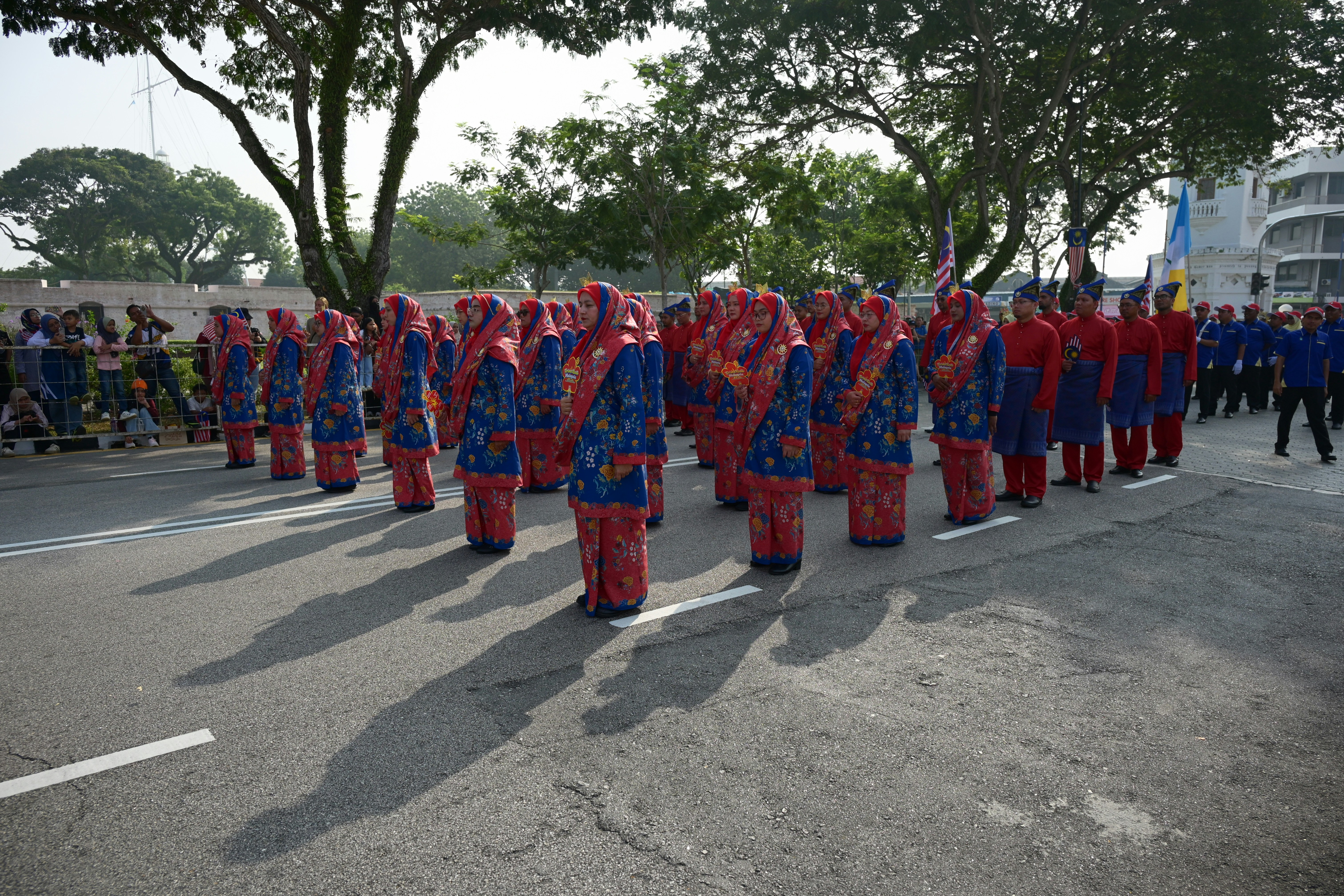 Marching in Color: a synchronized parade of red-and-blue ensemble in a sunlit plaza
