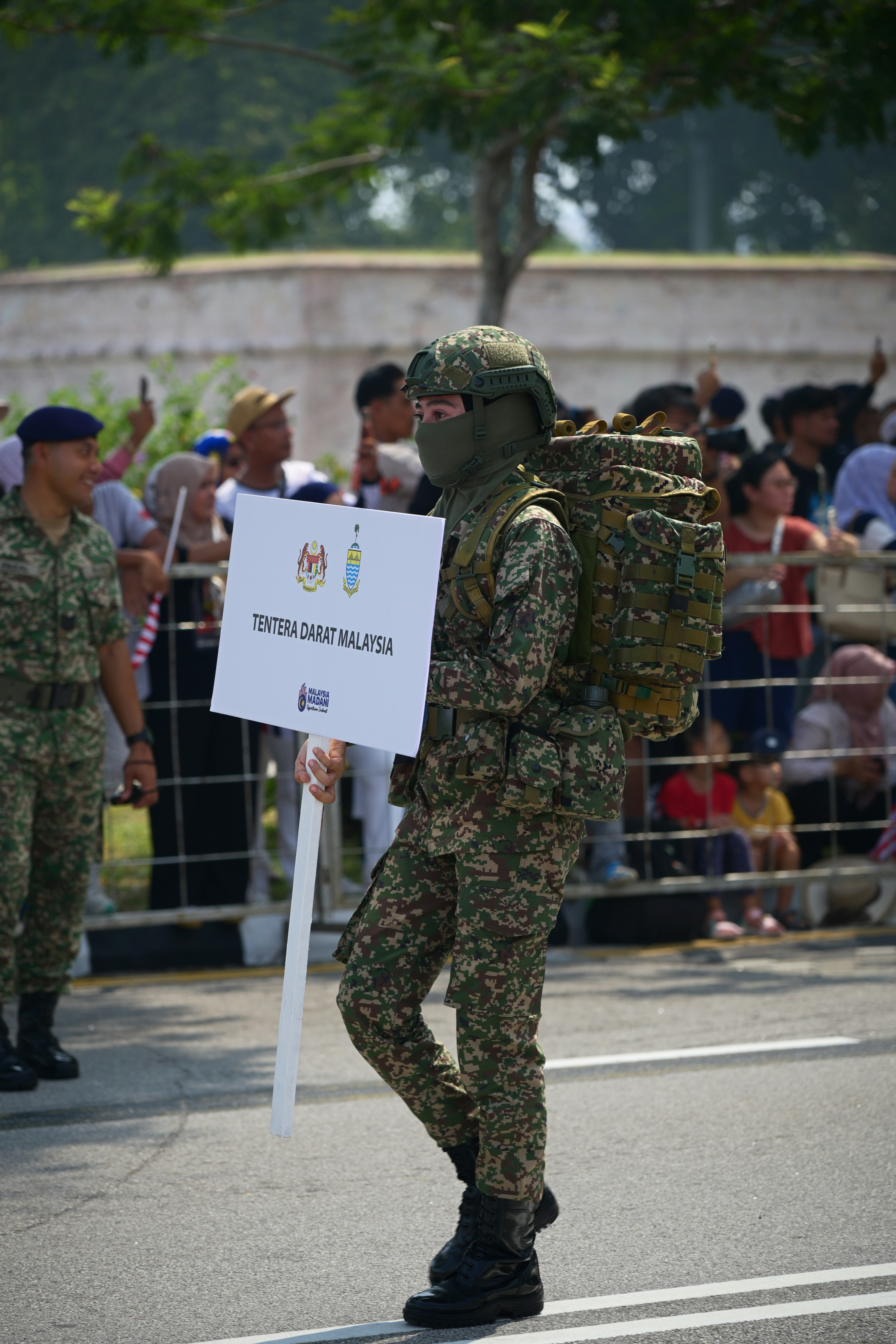 Masked Soldier with Sign Leads a Public Demonstration