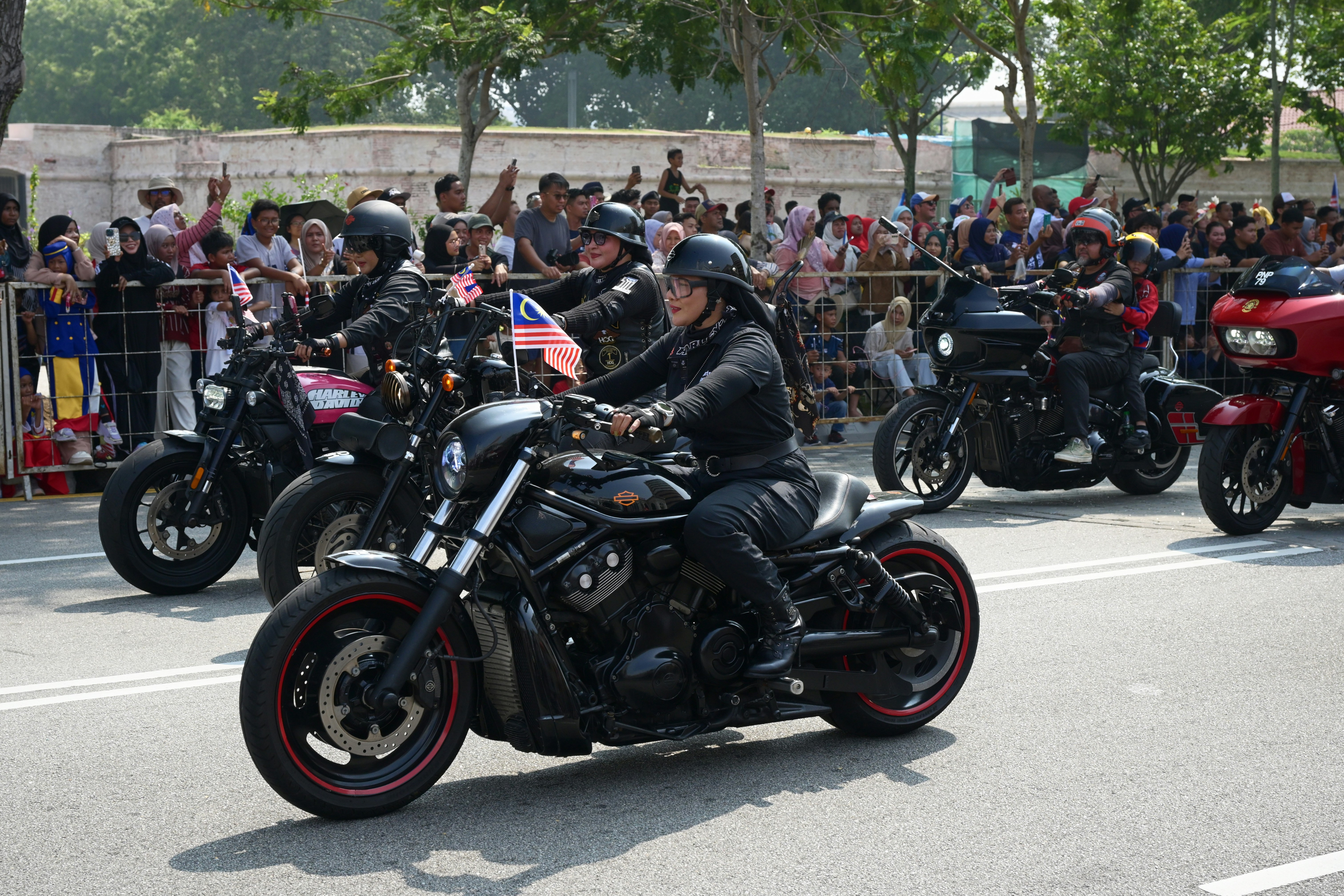 Bold Ride and Crowd: Black motorcycle lead with a cheering street parade