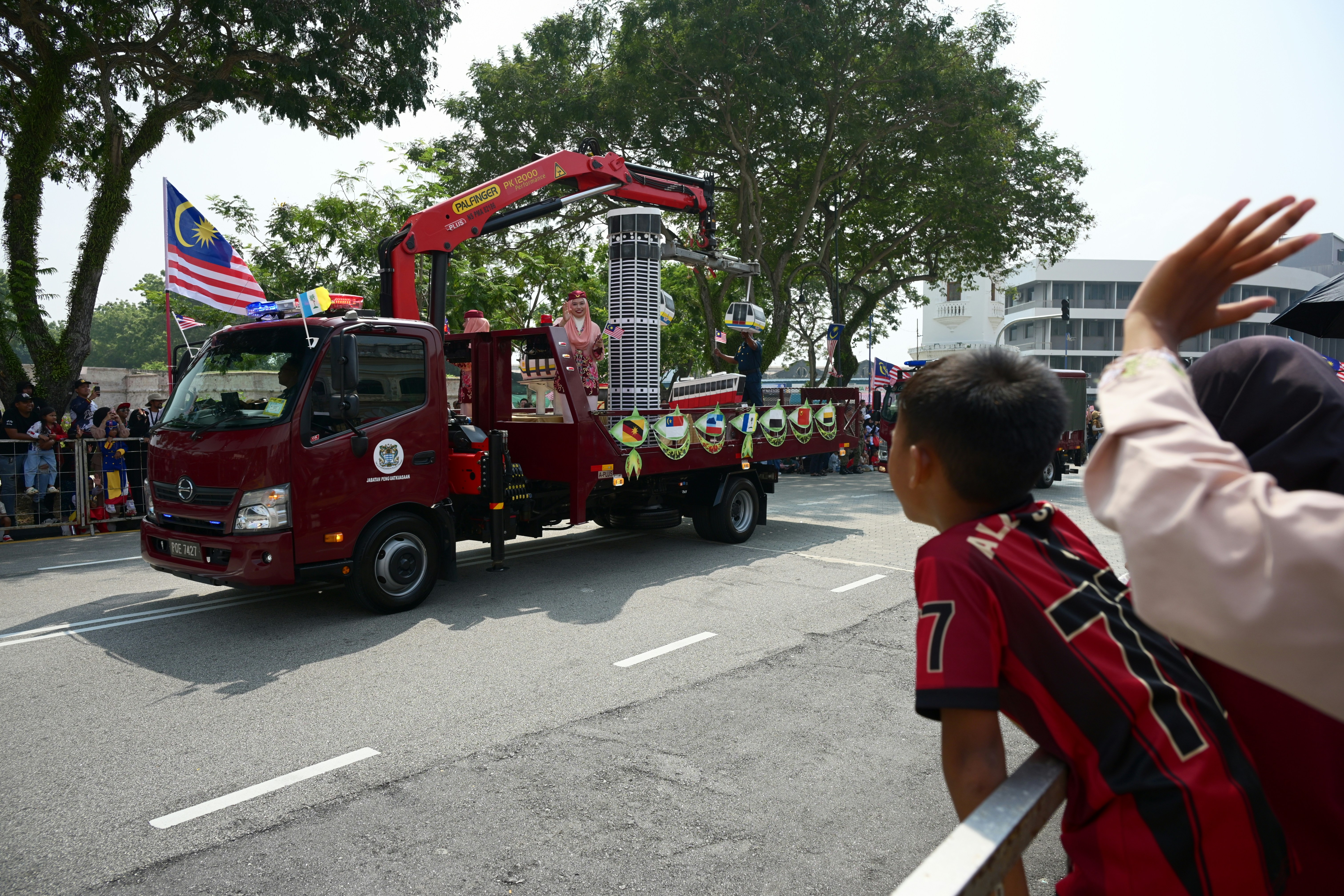 Parade Workhorse: A Red Crane Truck Marches Forward