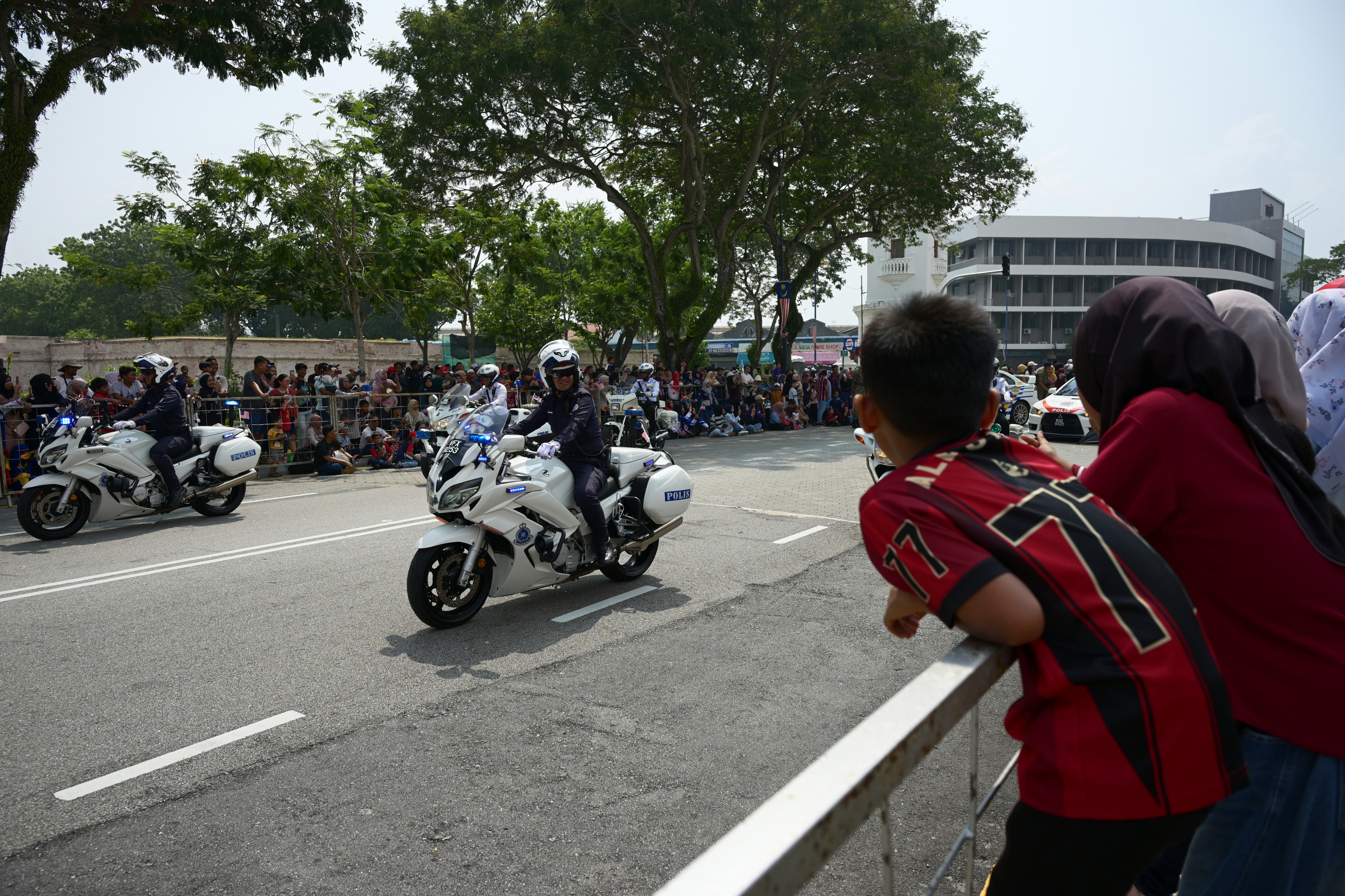 Guardians on Watch: Mounted Officers Lead Parade Past a Standing Crowd