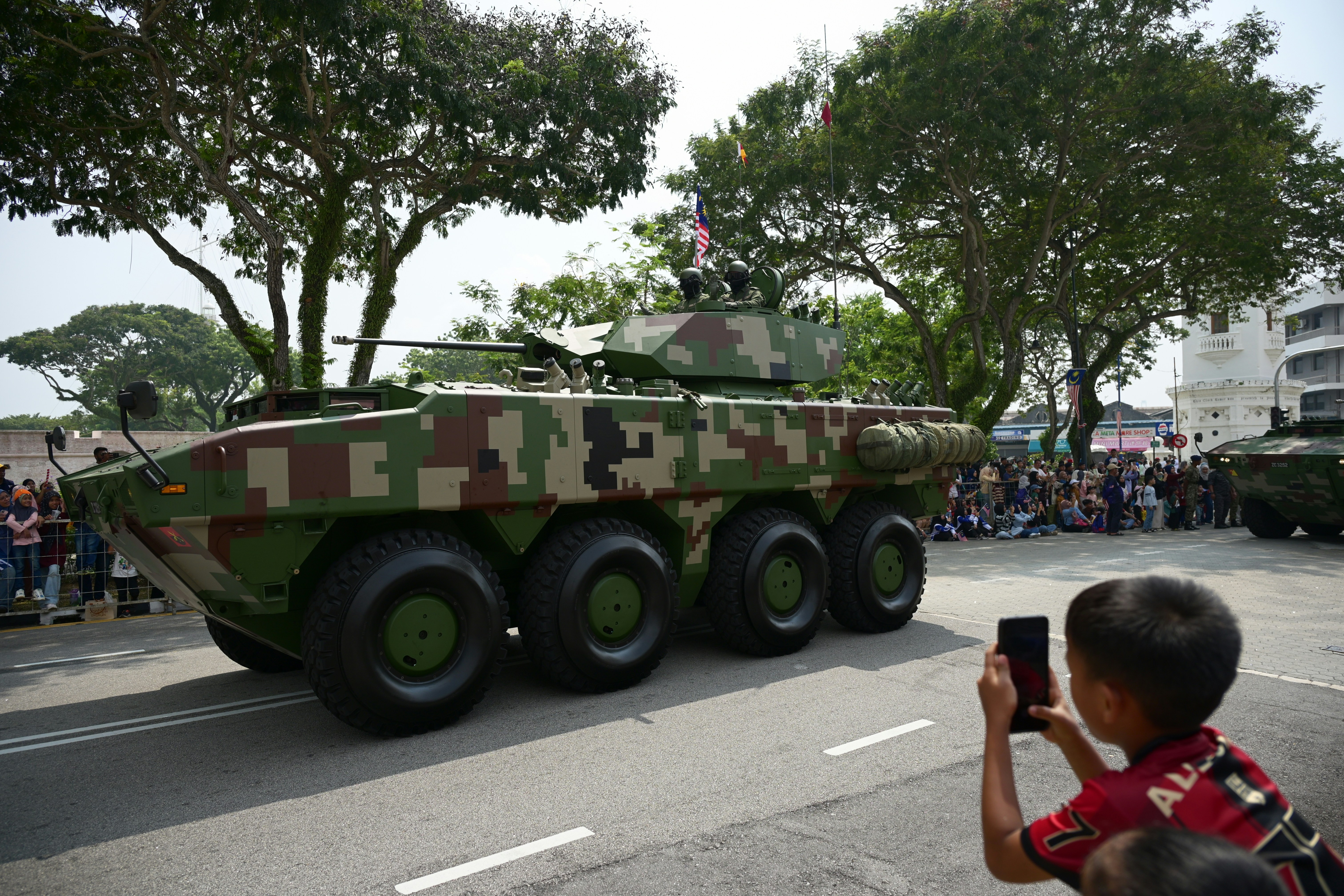 Colorful Armored Parade: Citizens Photograph a Camouflaged Vehicle