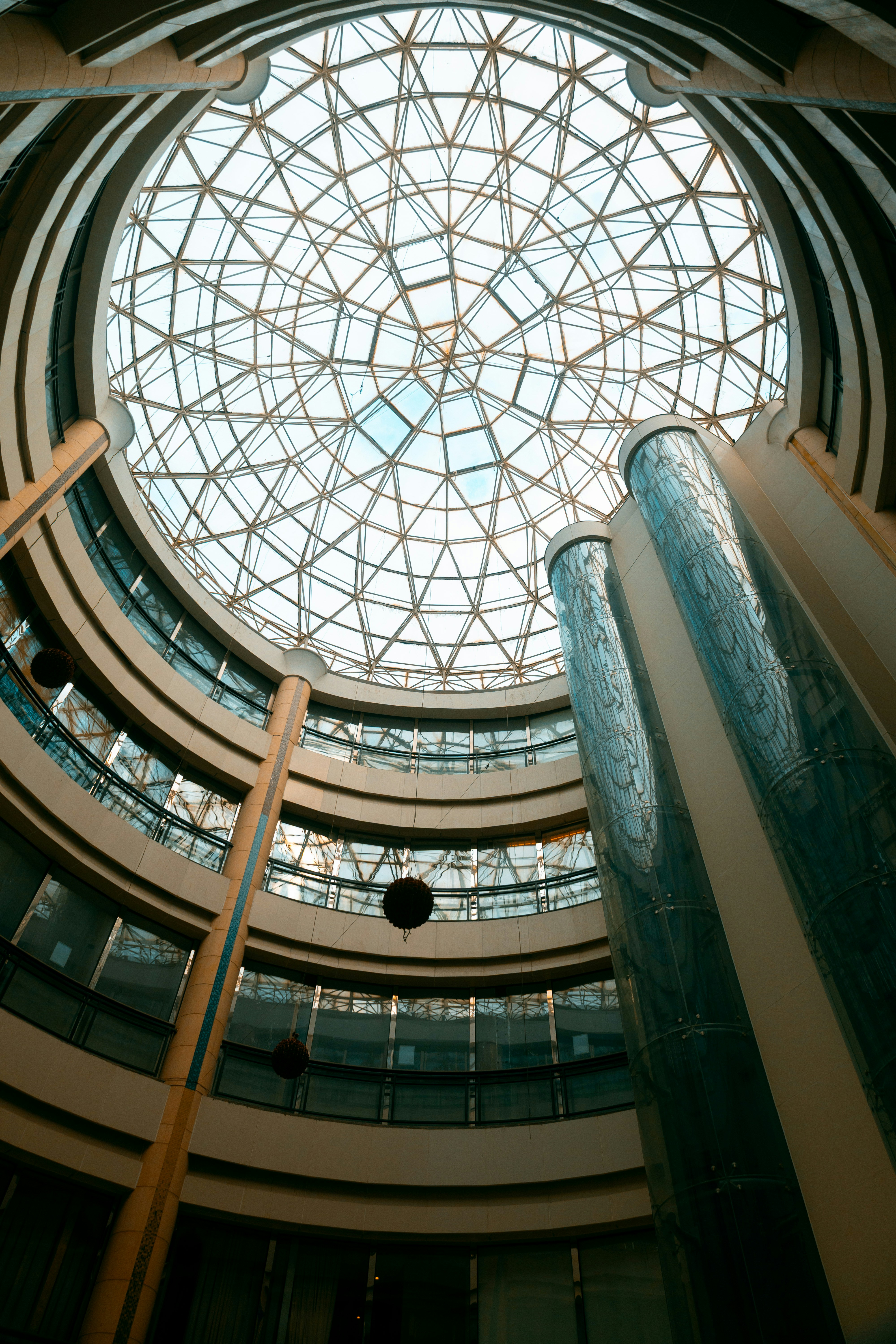 Glass Dome Convergence: A Spiral Atrium Framed by Cascading Columns