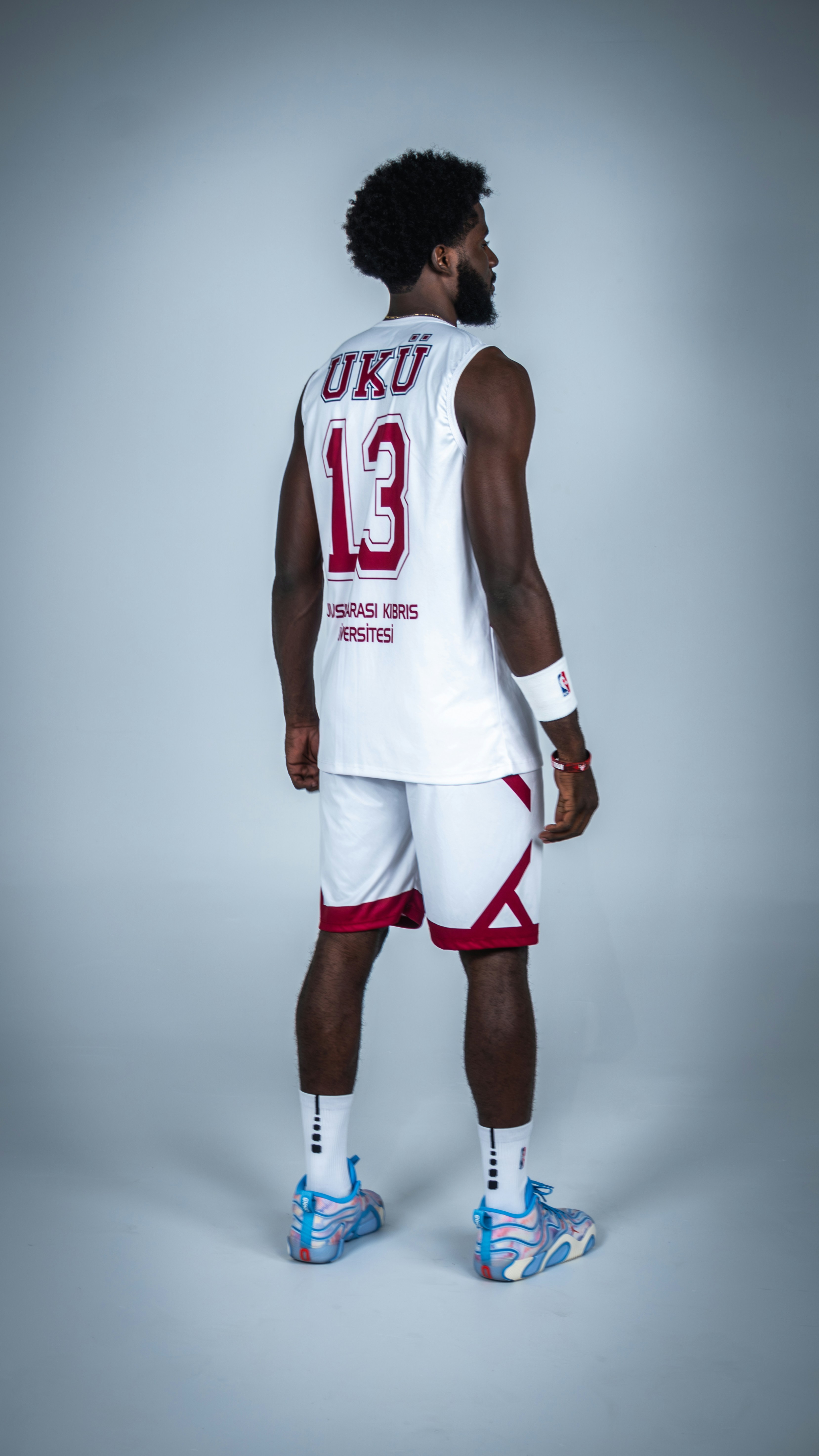 Backturned Athlete in White Jersey with Red Accents