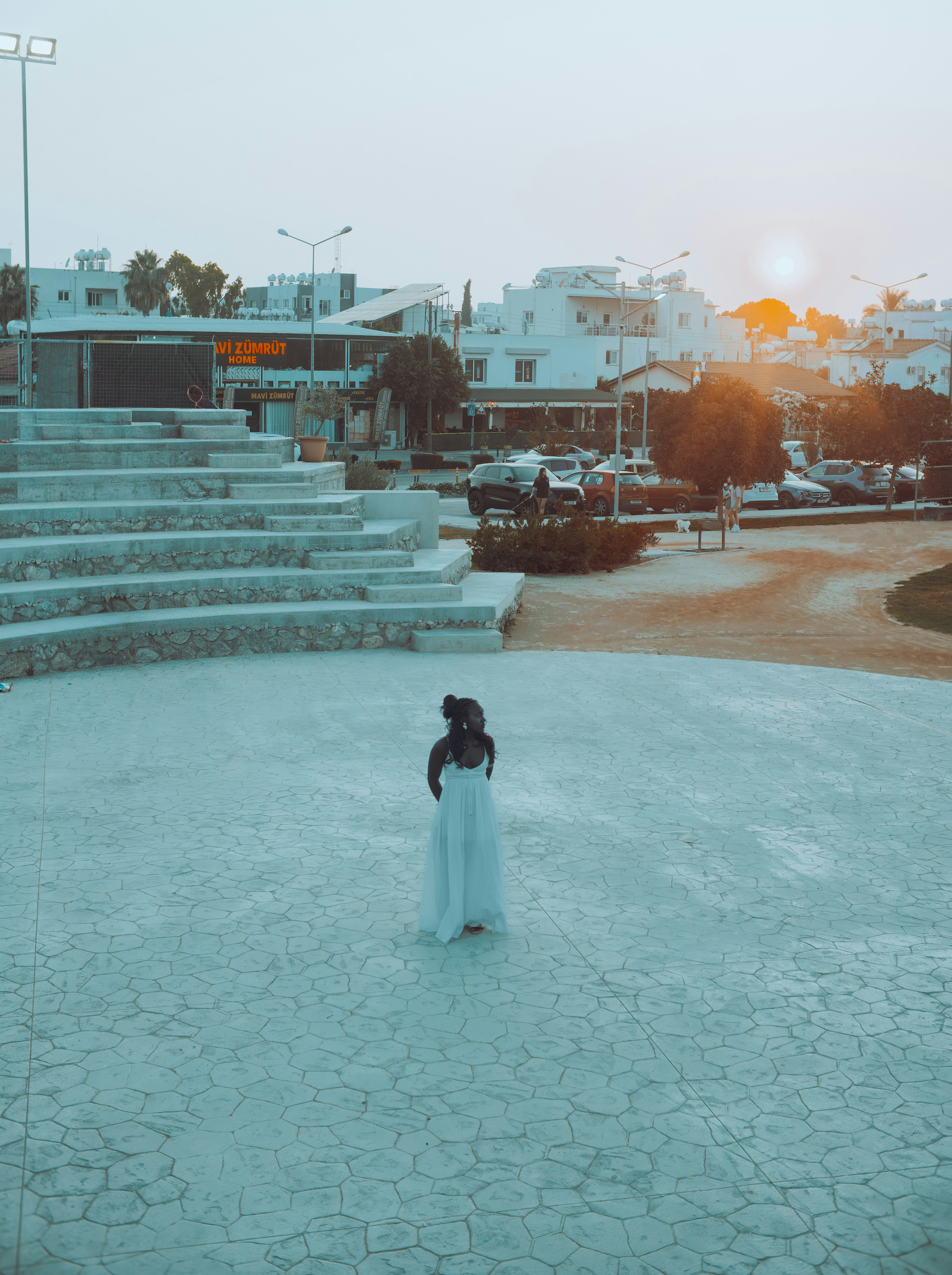 Solo in the Plaza: A Pale Bride Beneath the Evening Sky