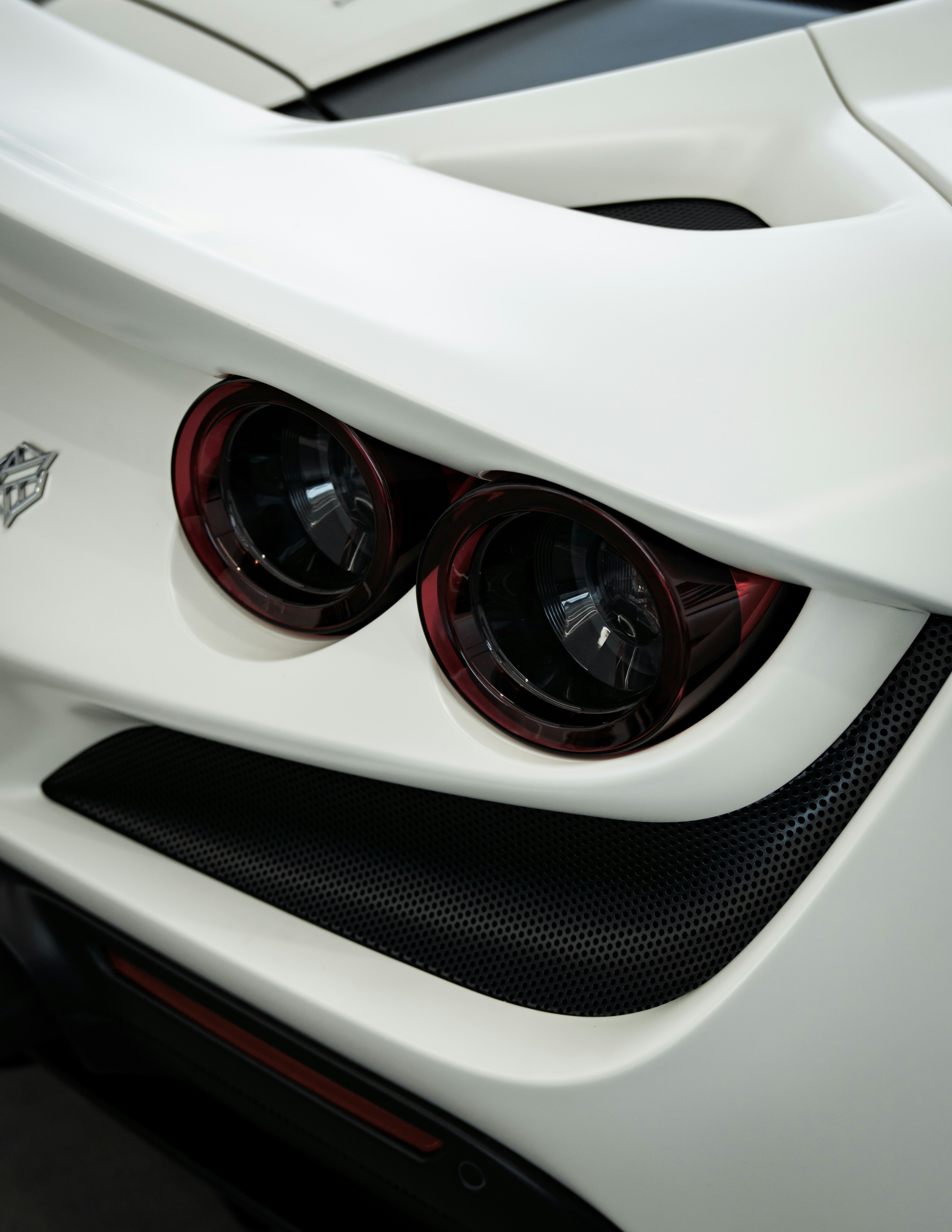 Rear Luminosity: Dual Red Circles on White Carbon-Backed Corvette-Style Tail