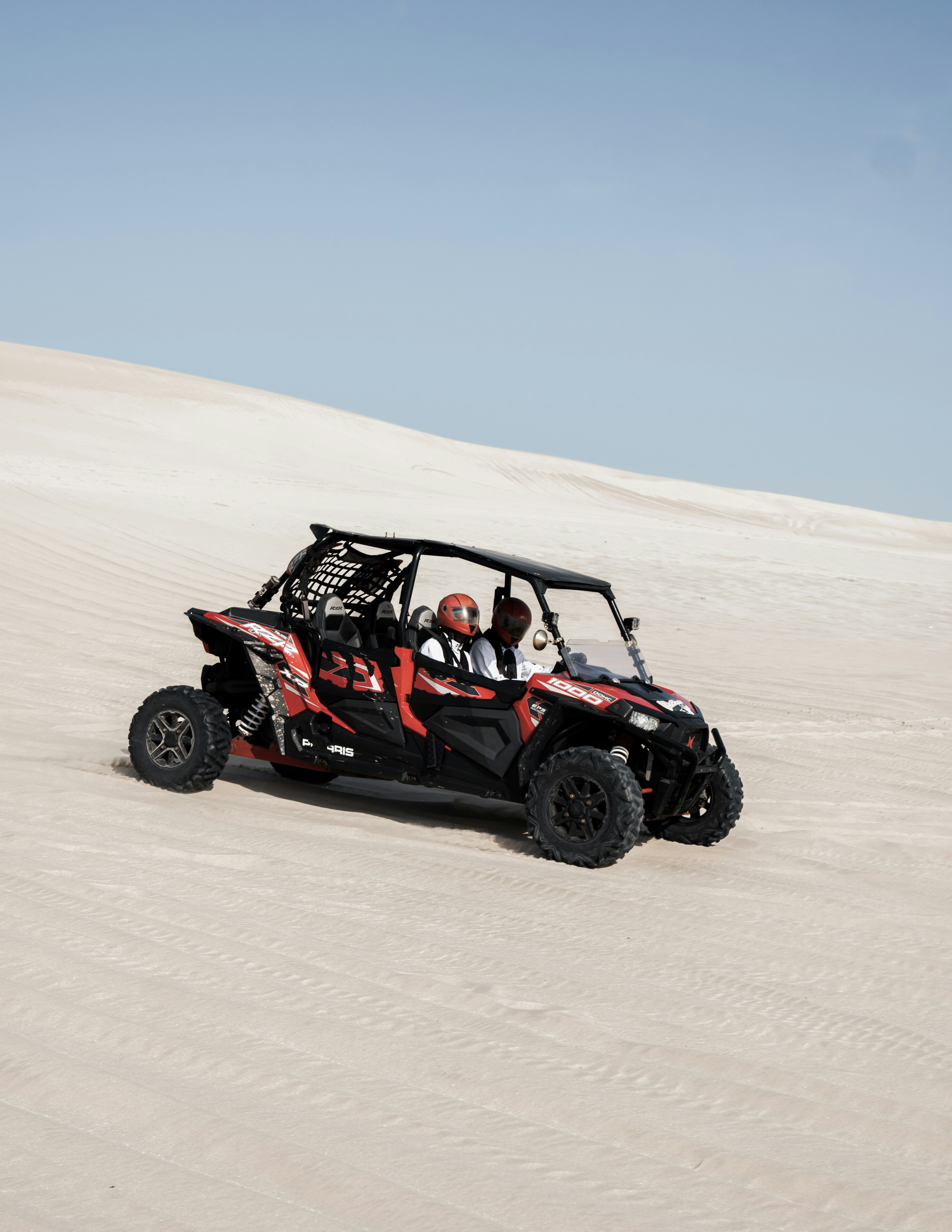 Red Off-Road Polaris Dune Cruiser Cutting Through Quiet Sand Waves