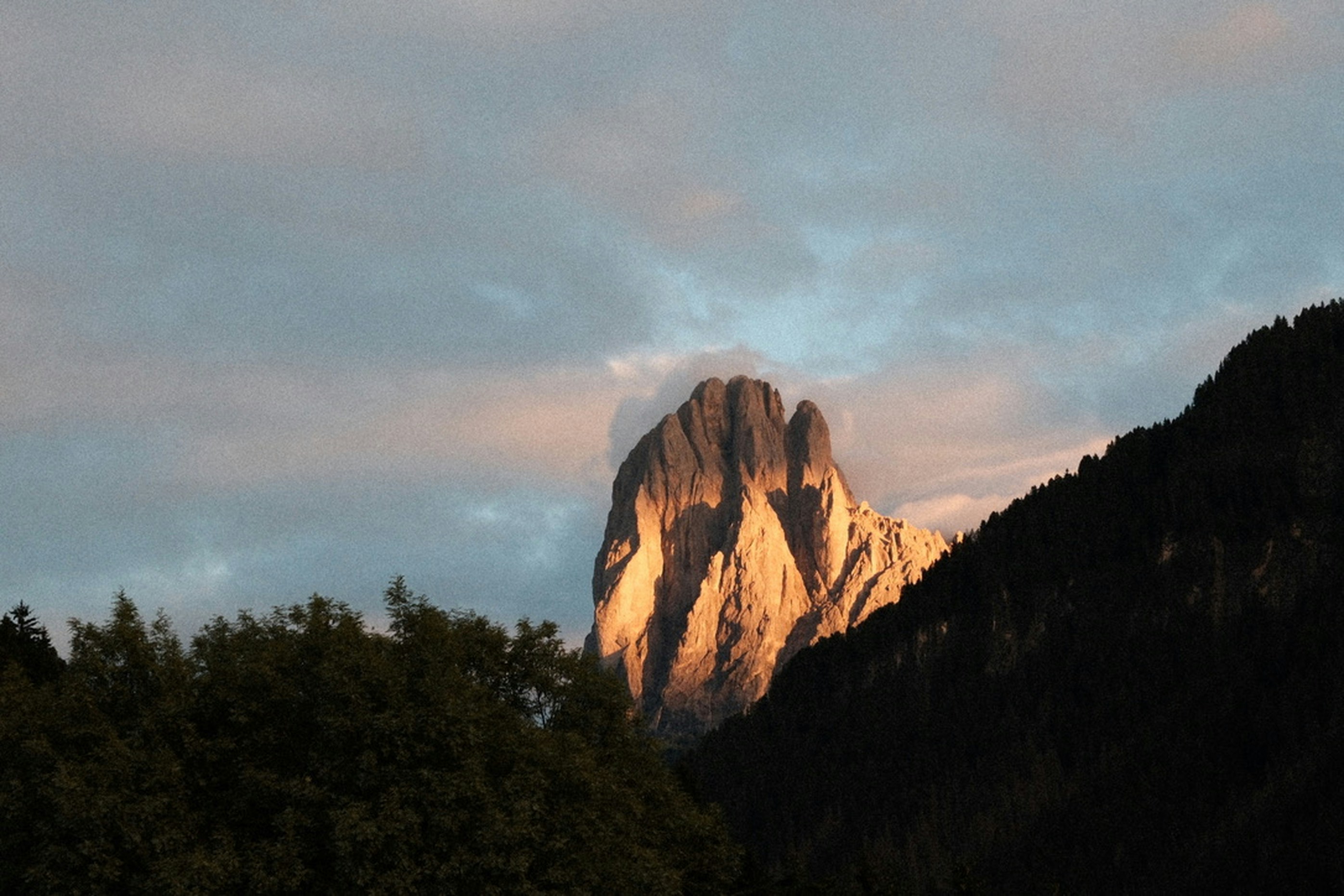 Sunlit Peak: A Lone Summit Rises Above the Forest