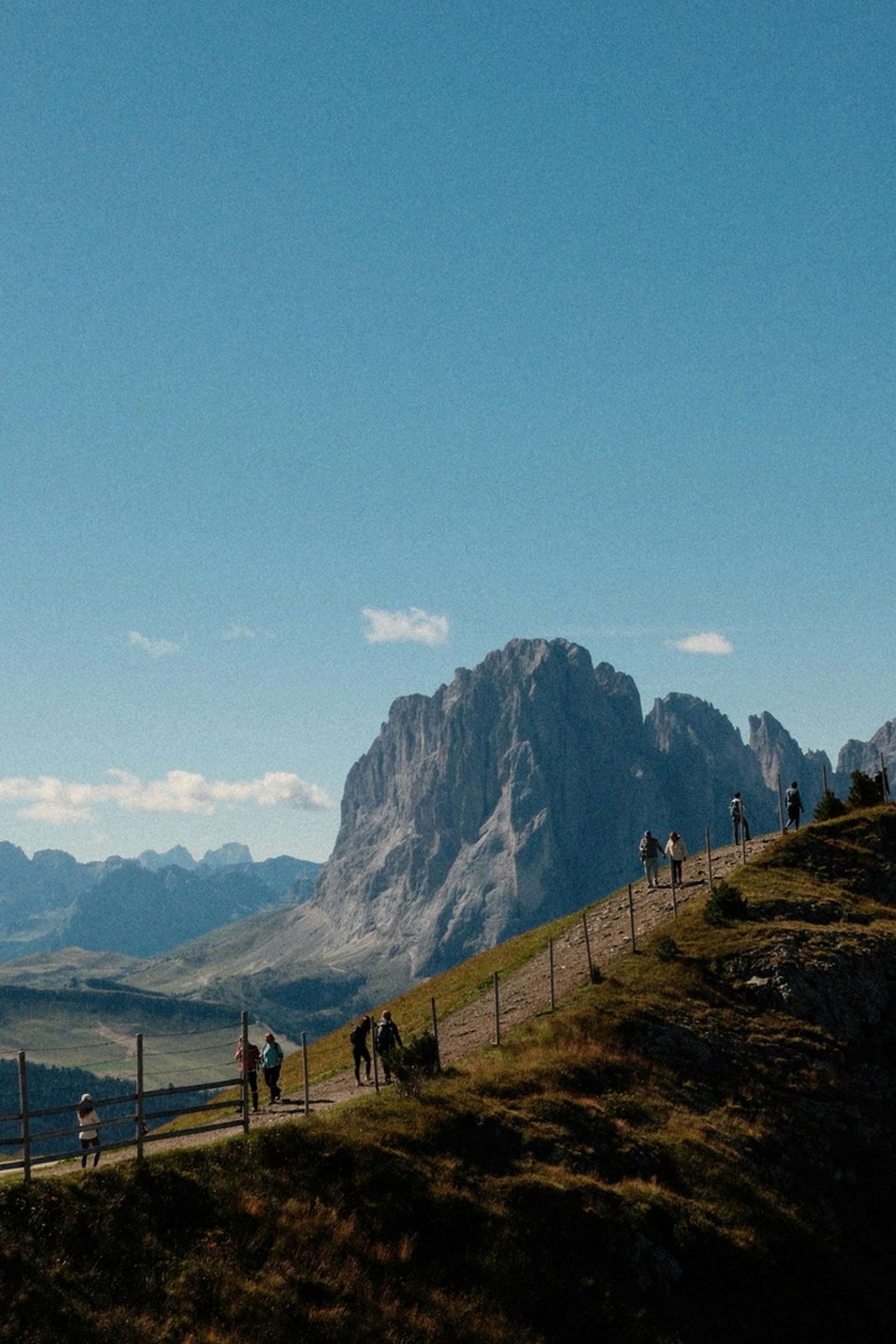 Hikers Ascend the Ridge Beneath a Lofty Mountain Backdrop