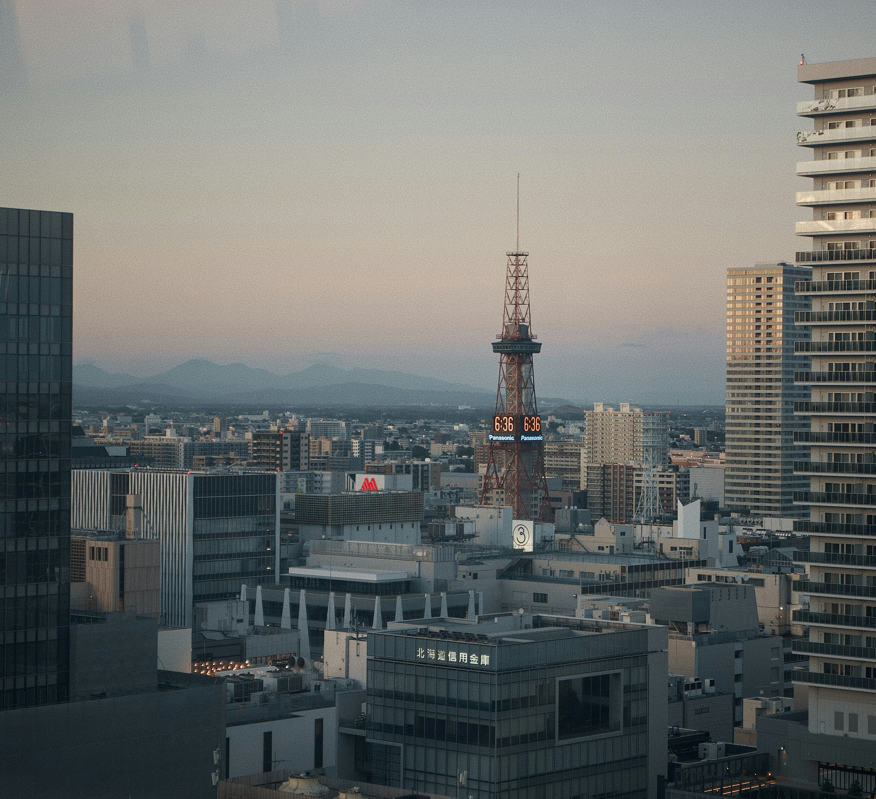 City Crest: Antenna Tower Rising Above the Rooftops at Dusk