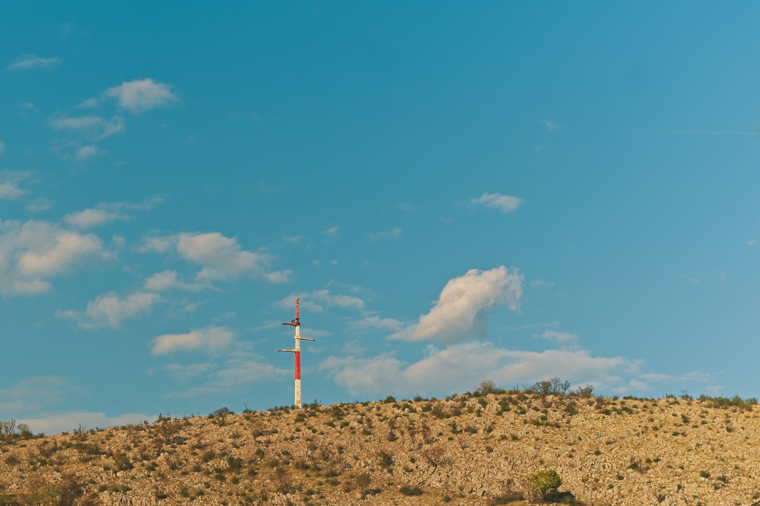 A Lone Antenna Rises Over a Dry Sloped Horizon