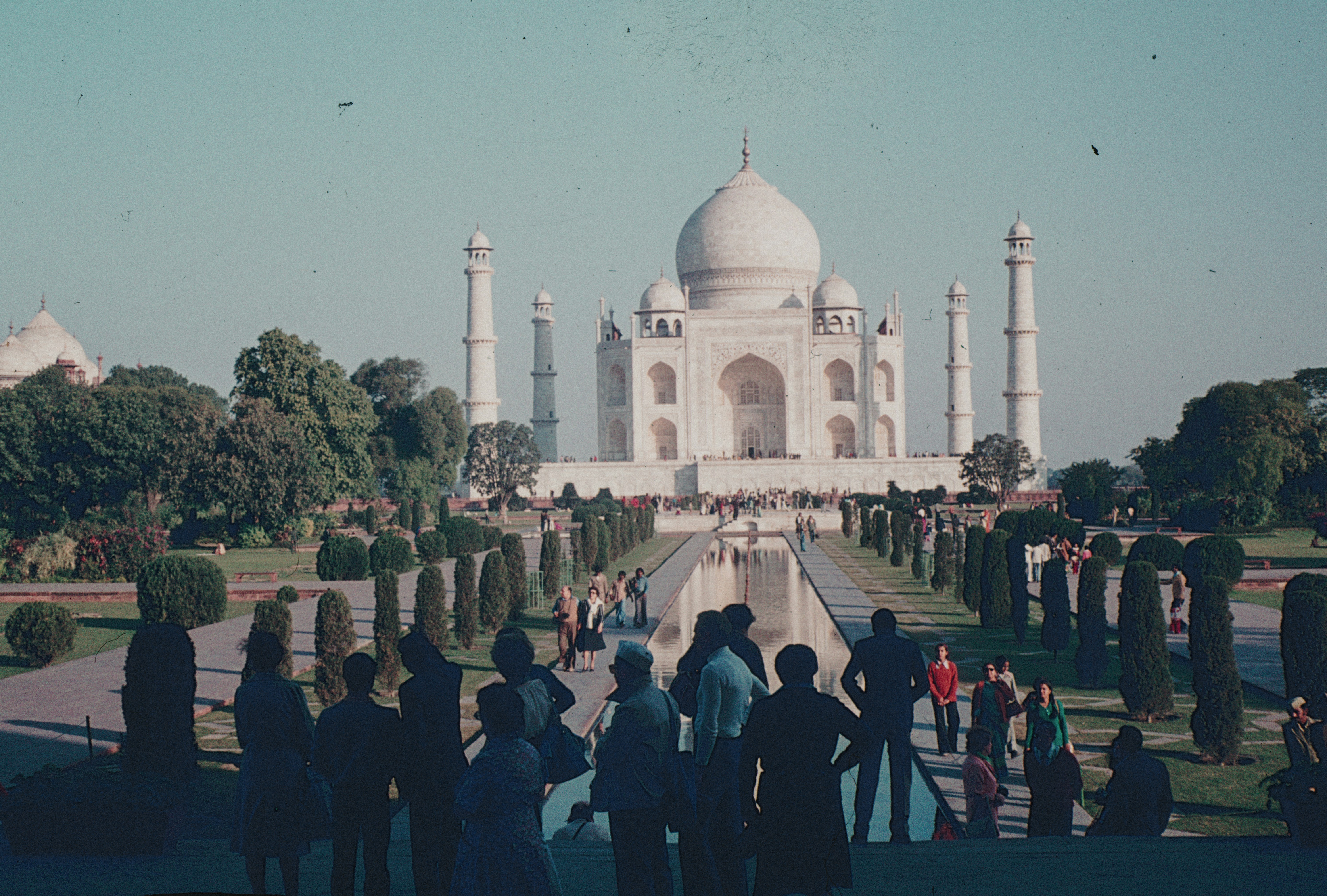 Symmetry at the Marble Gate: Tourists Crossing the Reflective Axis to the Taj Mahal
