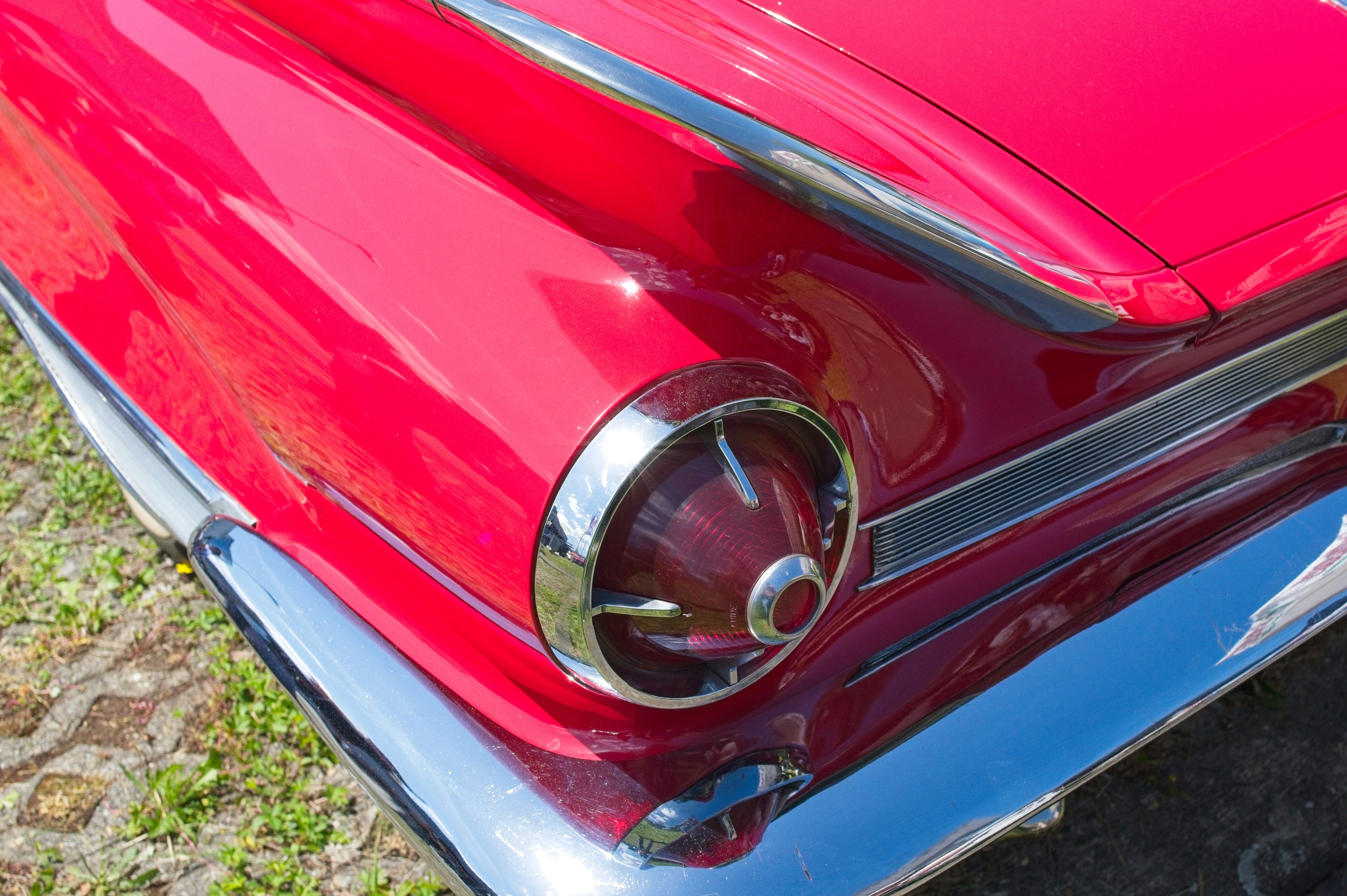 Red Buick's Gleam: Chrome and Tailfin in Focus