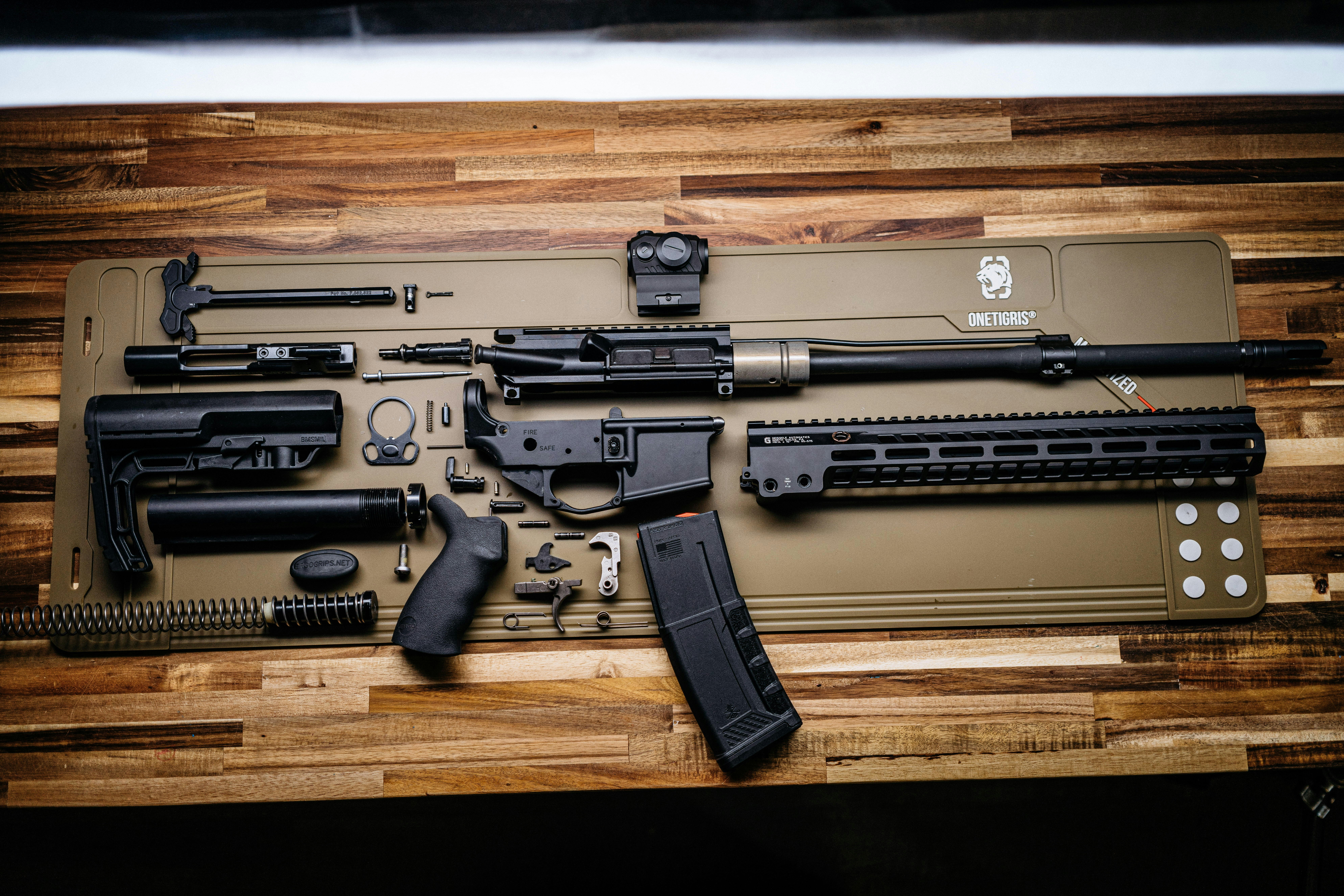 Disassembled precision rifle laid out on a work mat with tools